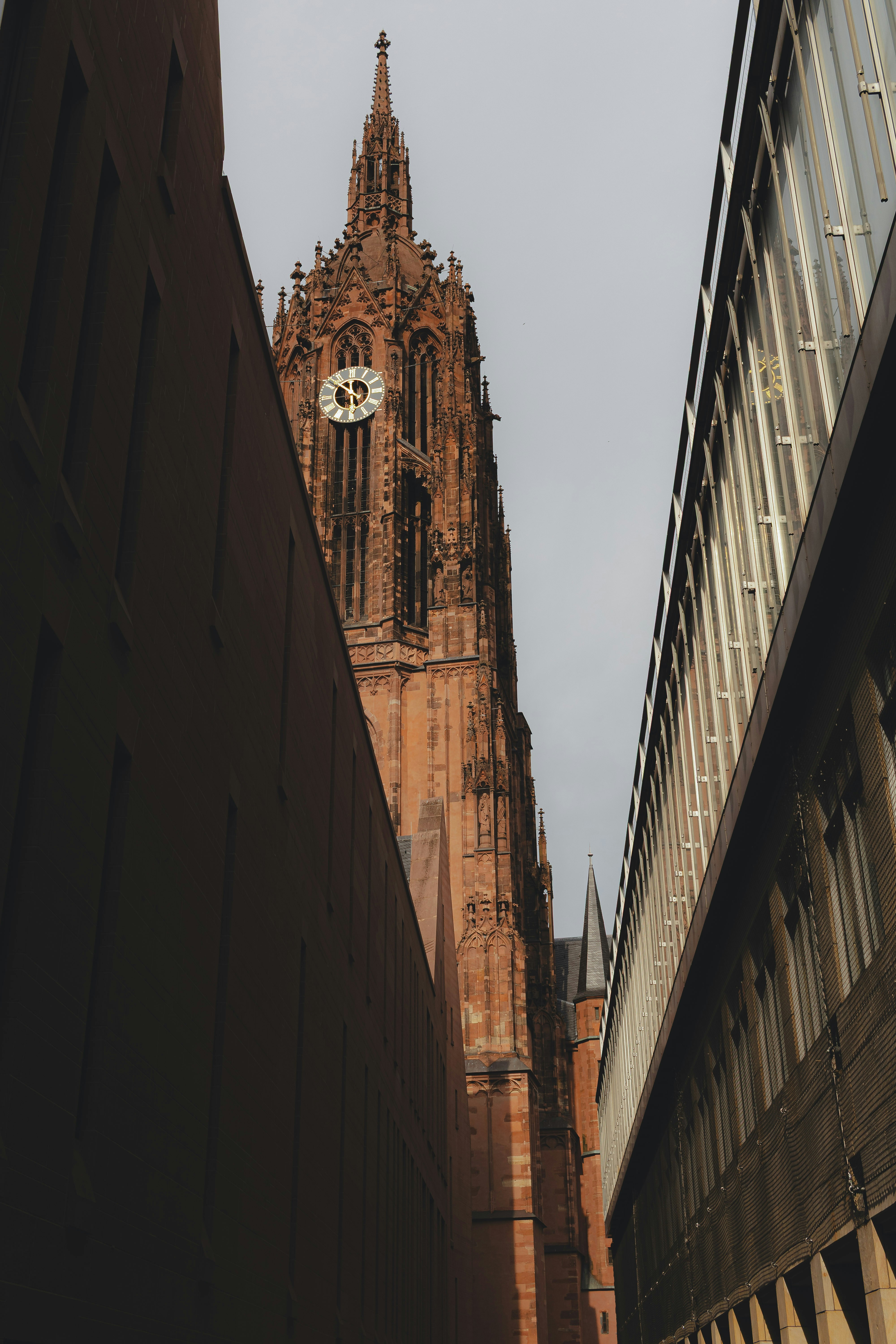A towering church spire viewed between buildings.