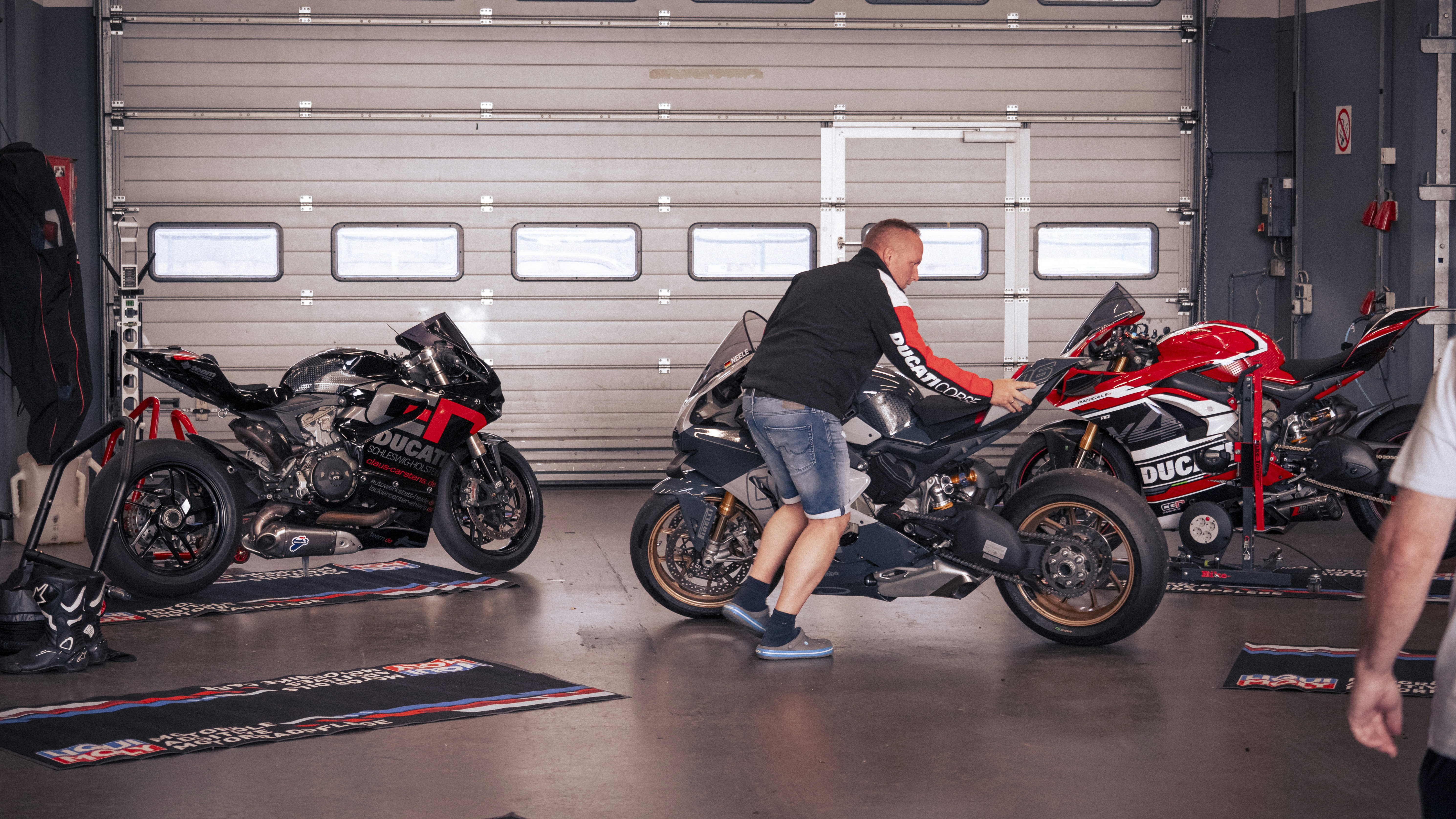 Man pushing a motorcycle in a garage. photo – Free Motorbike Image on ...