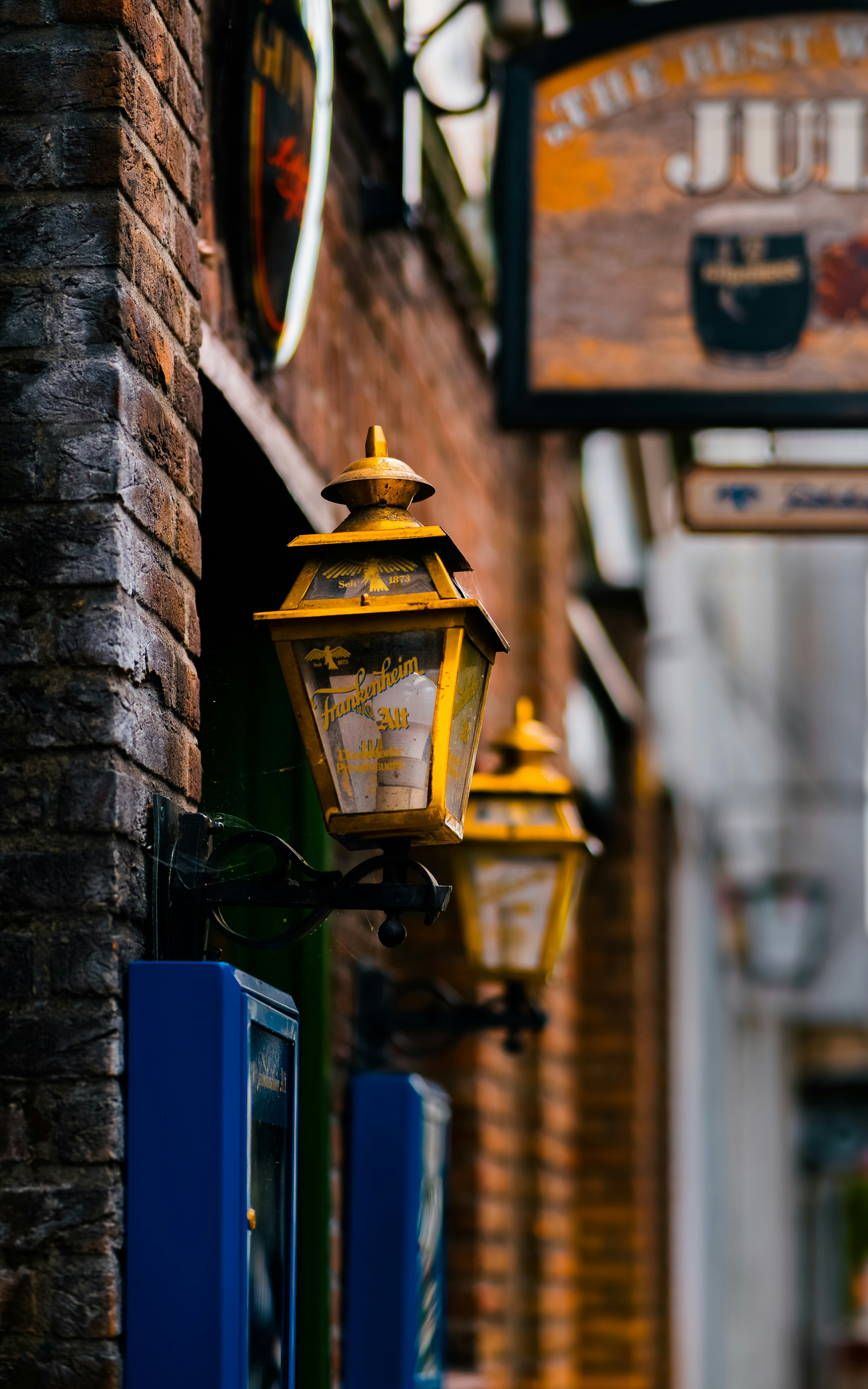 Lanterns are affixed to a brick wall.