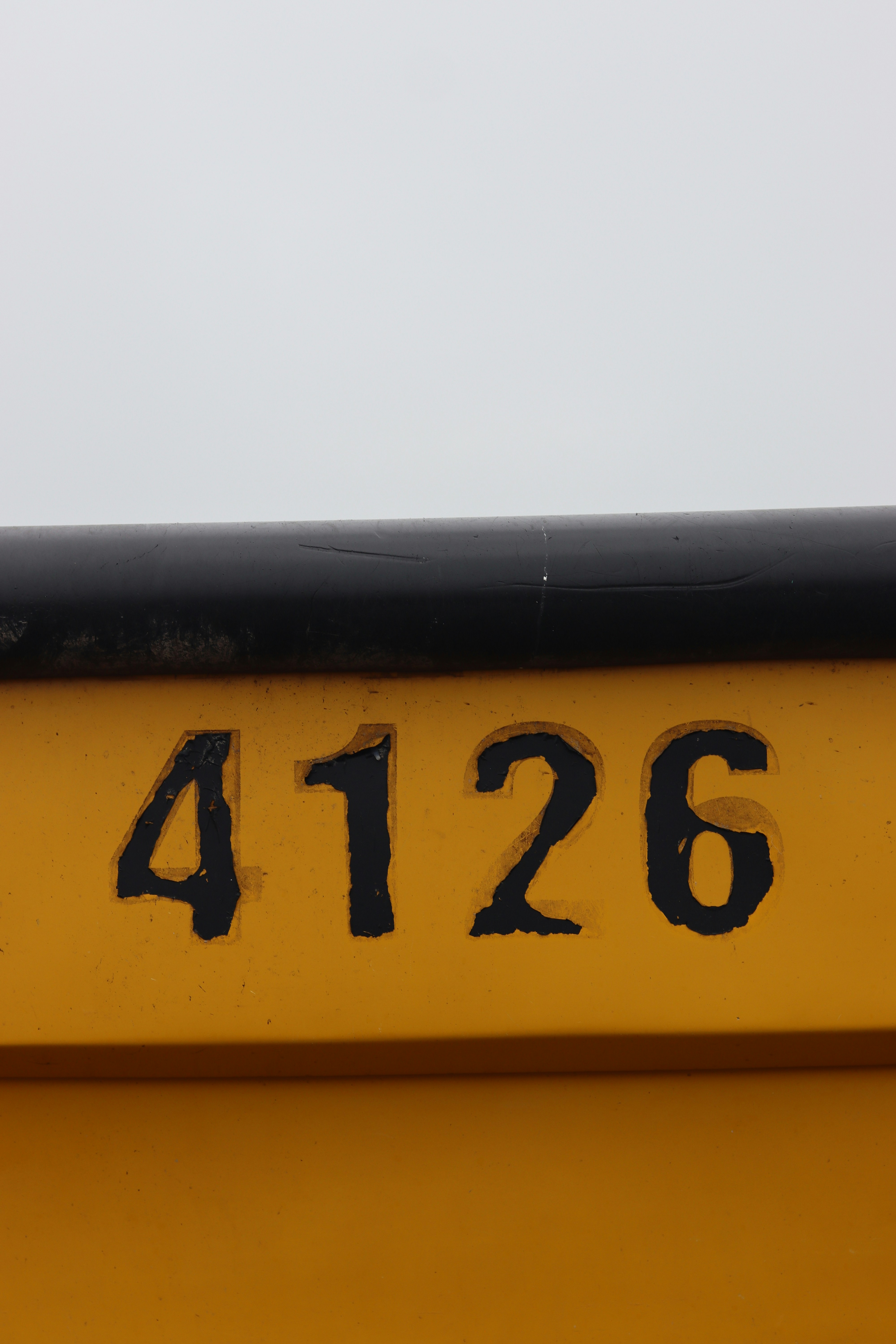Bold black numbers '4126' on a yellow surface, hinting at industrial usage or identification. The background is muted, emphasizing the numbers' prominence.