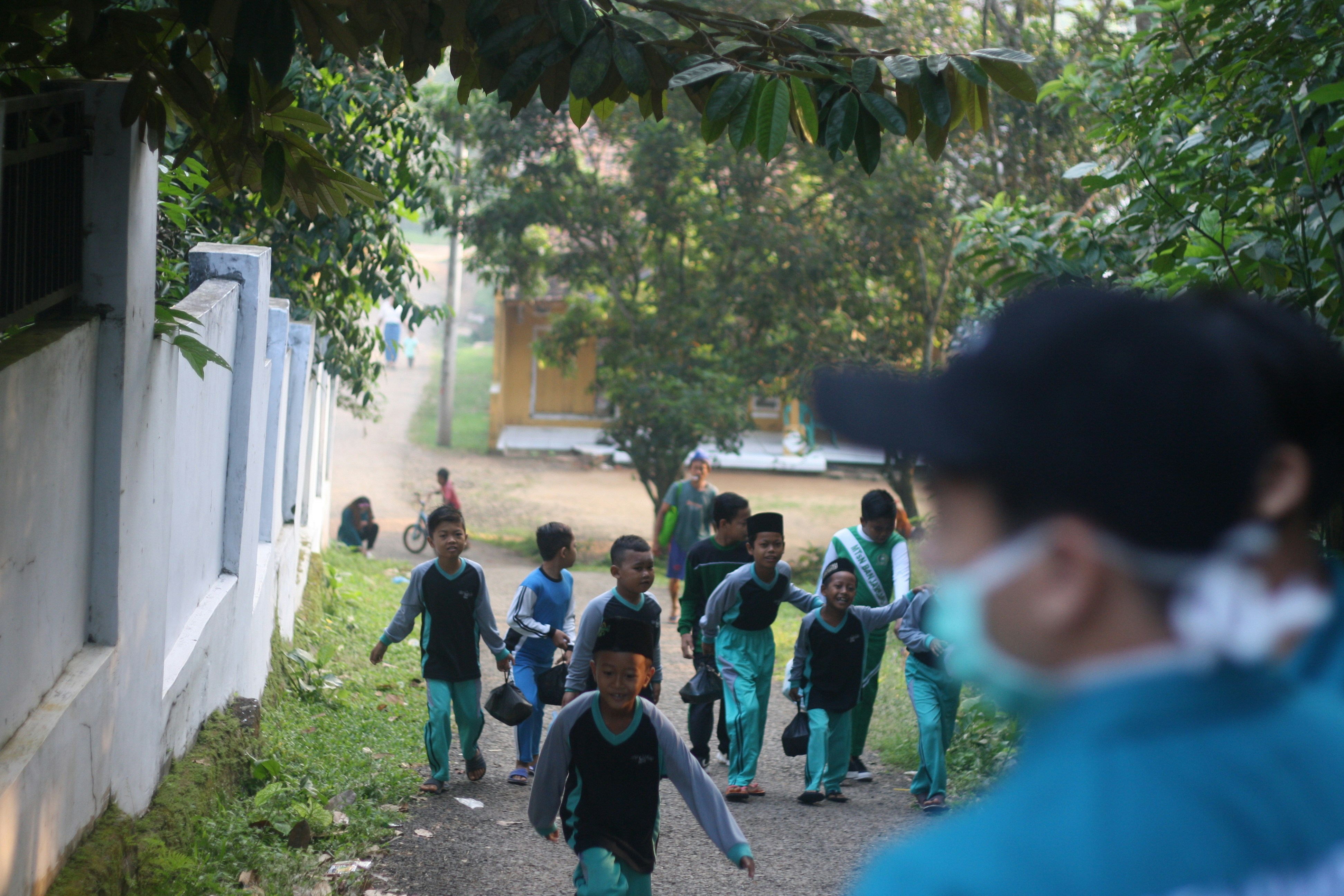 Bunch of kids walking down the street | Children are walking down a road.