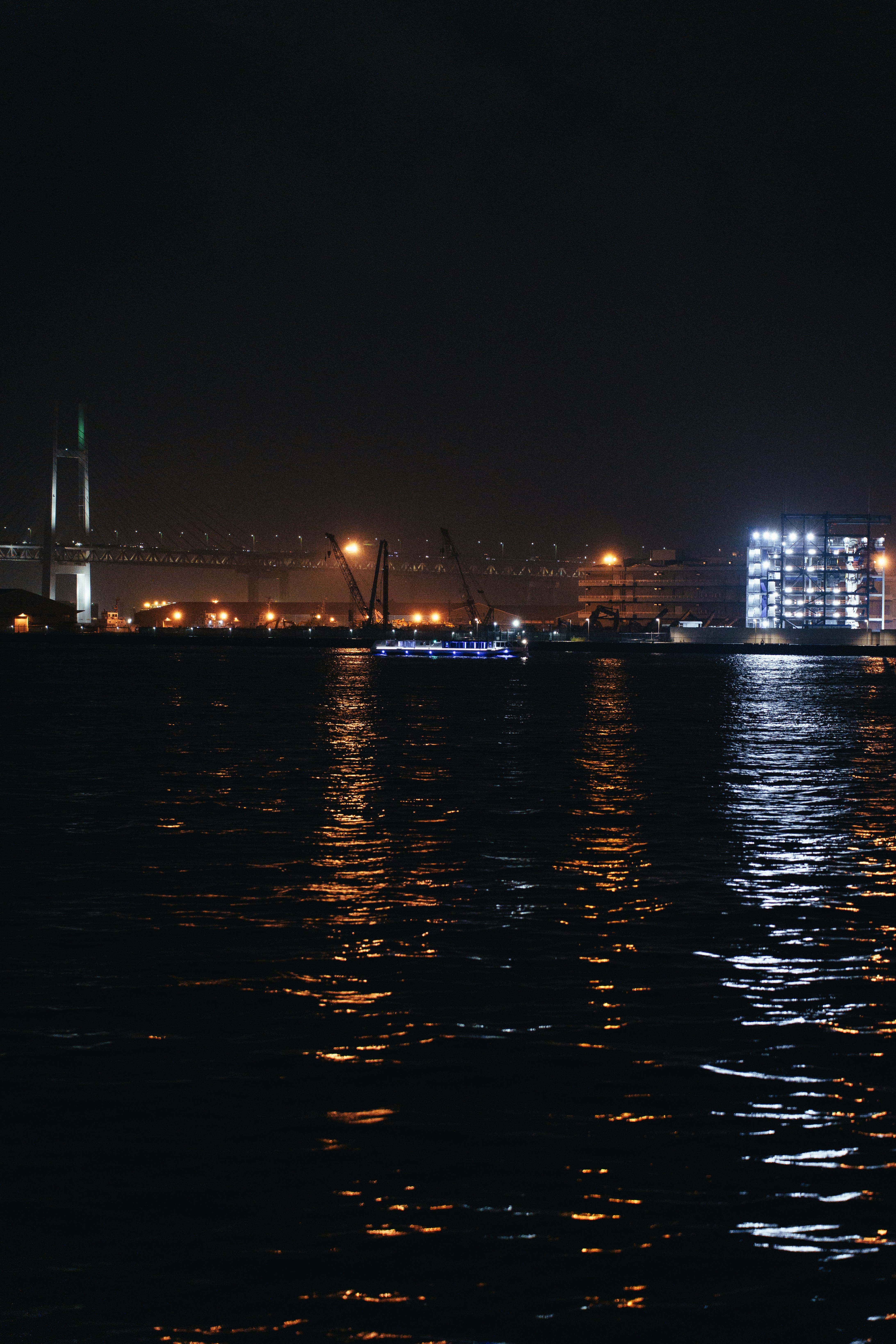 Nighttime cityscape reflected in the water.