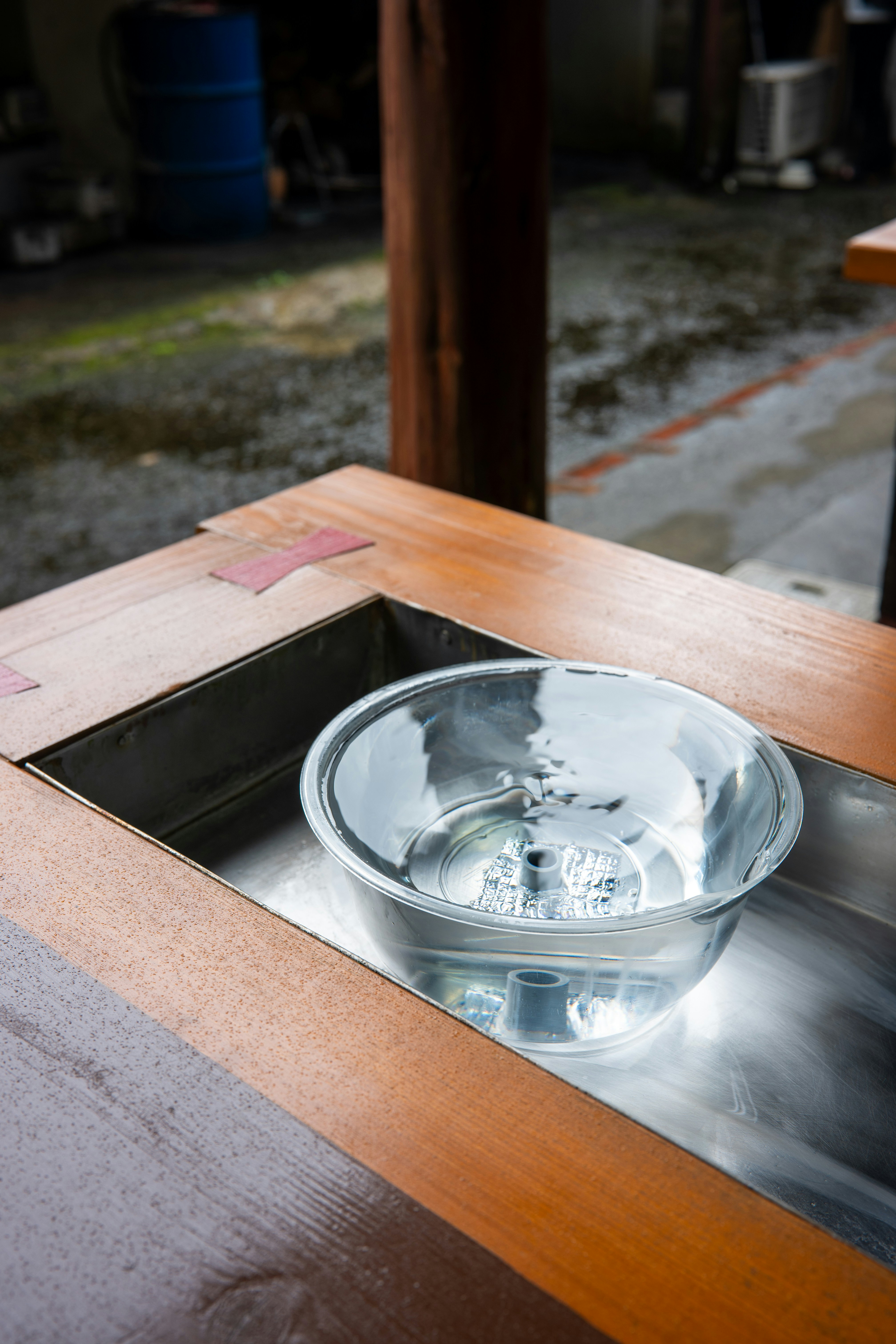 Copper-Edge Outdoor Basin Cradles a Glassy Vessel