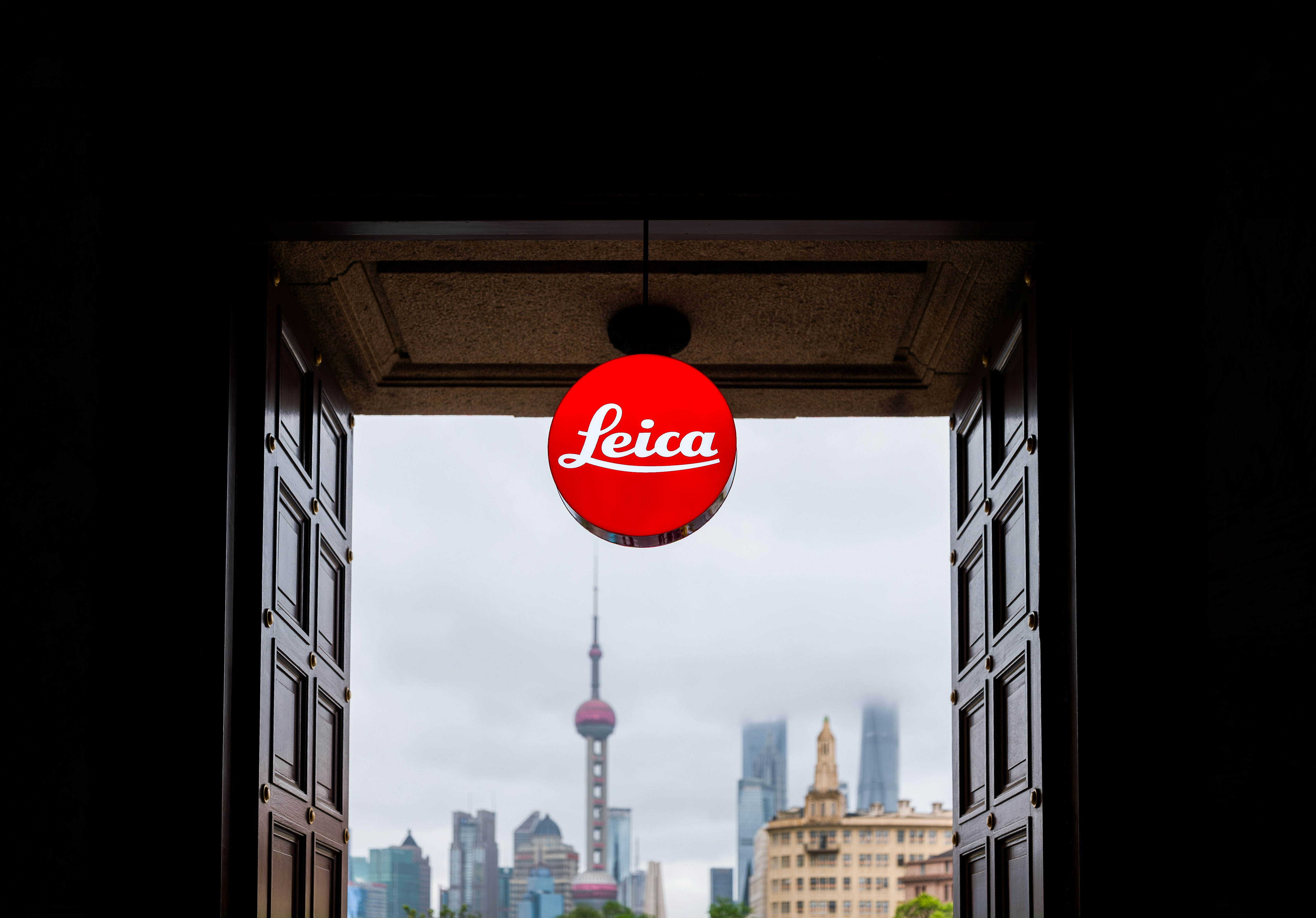 Leica sign framed by a doorway overlooking a skyline.