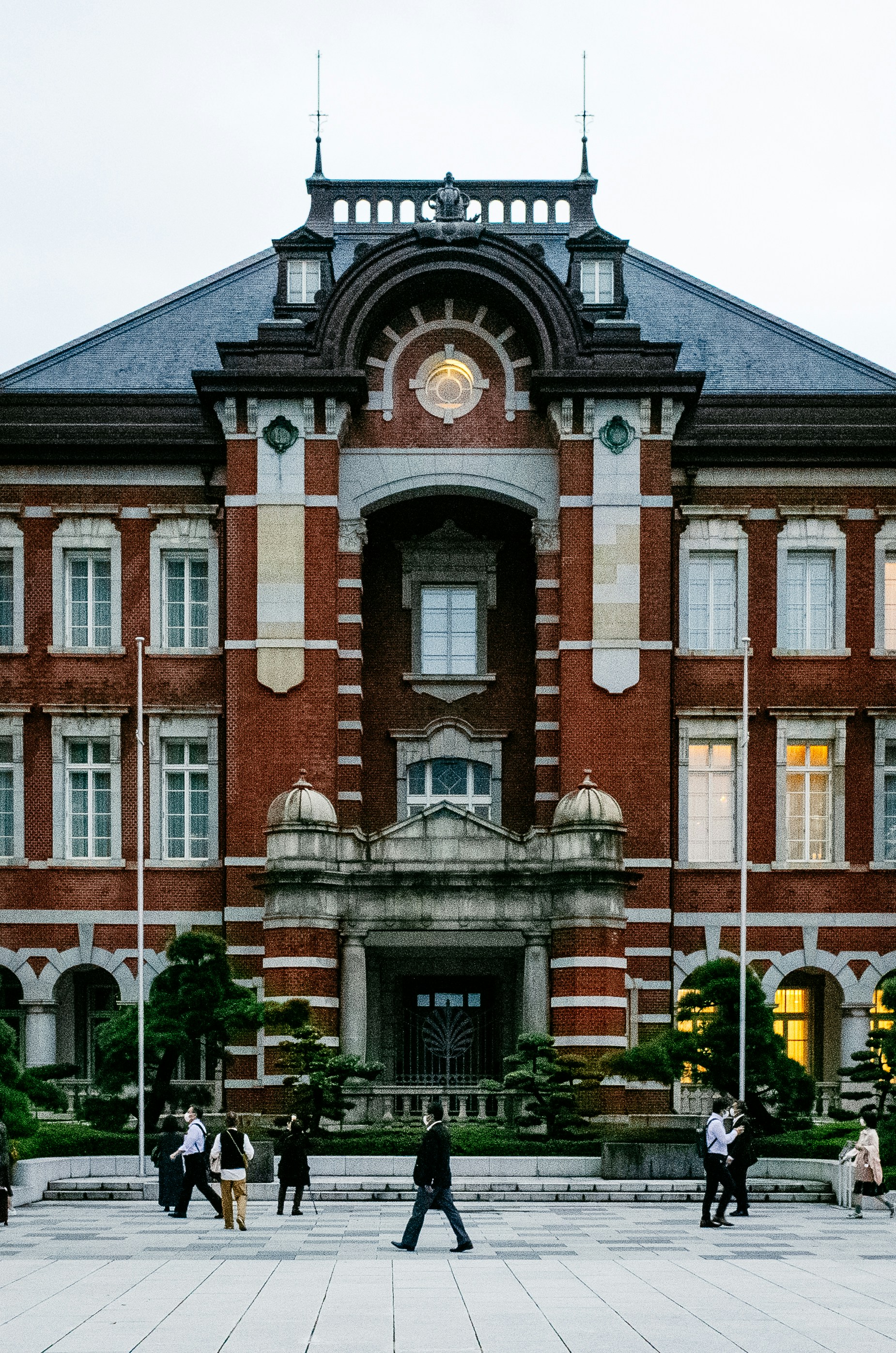 A beautiful brick building and busy plaza.
