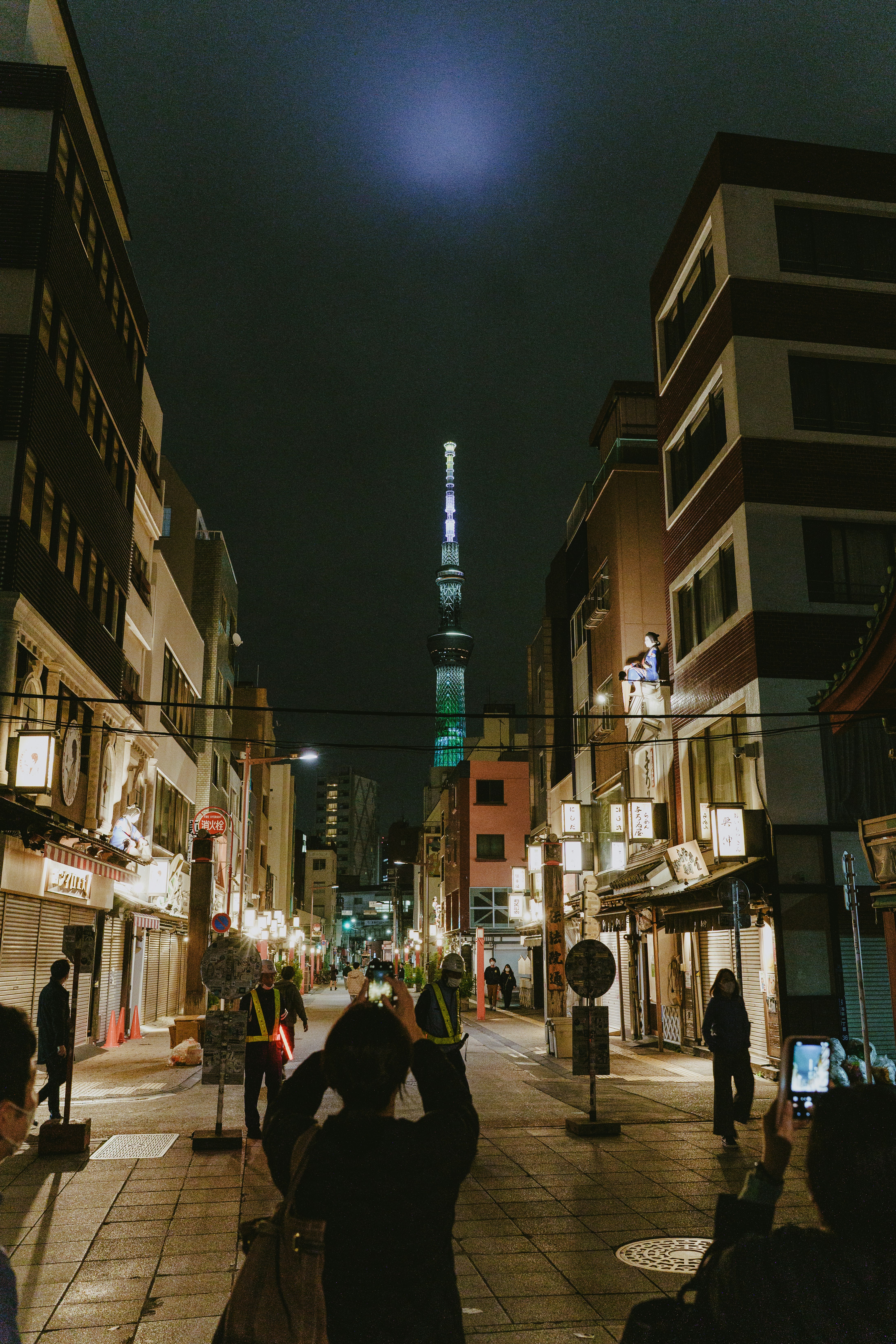 People take pictures of the tokyo skytree at night.