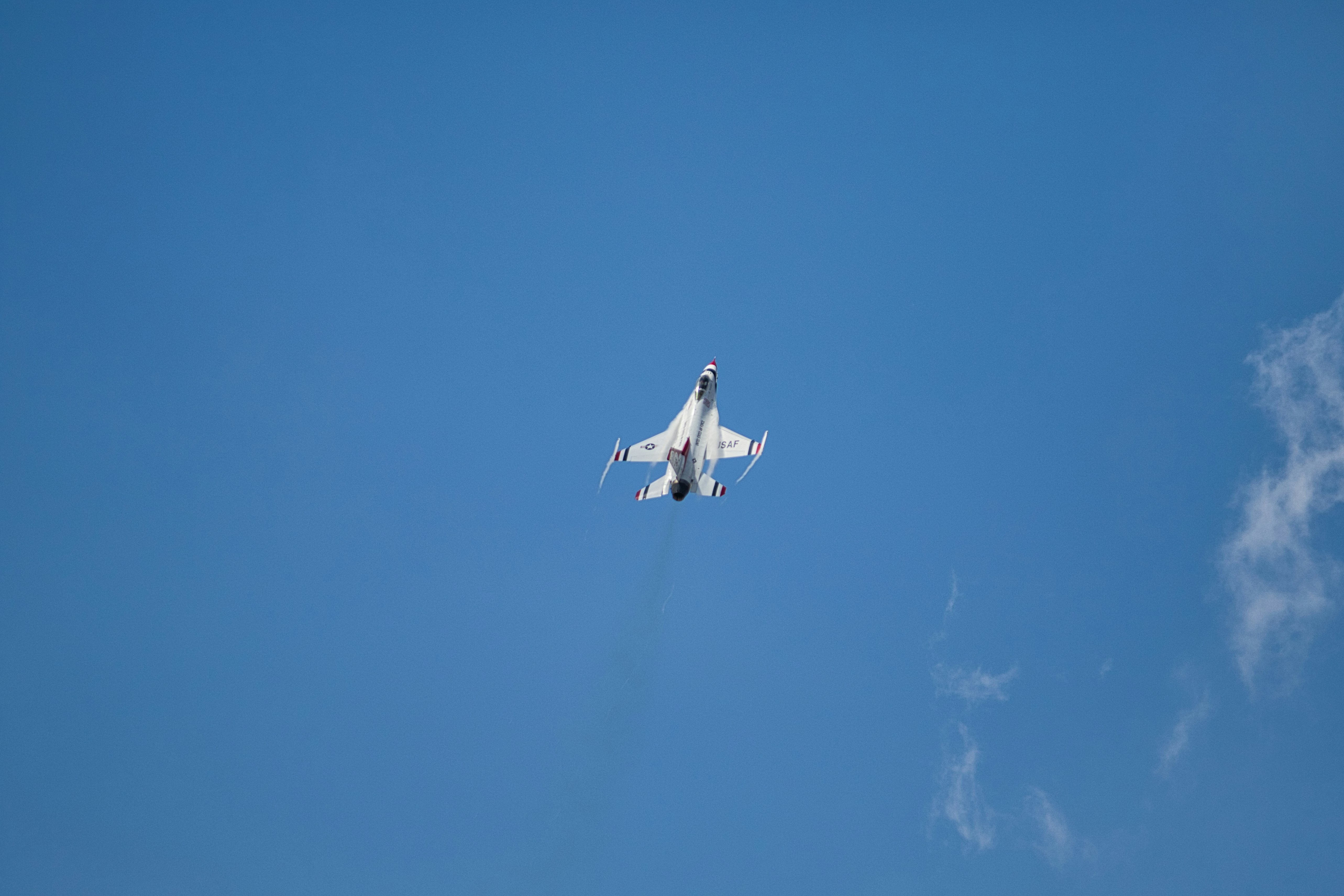 Thunderbirds | A fighter jet flies high in the clear blue sky.