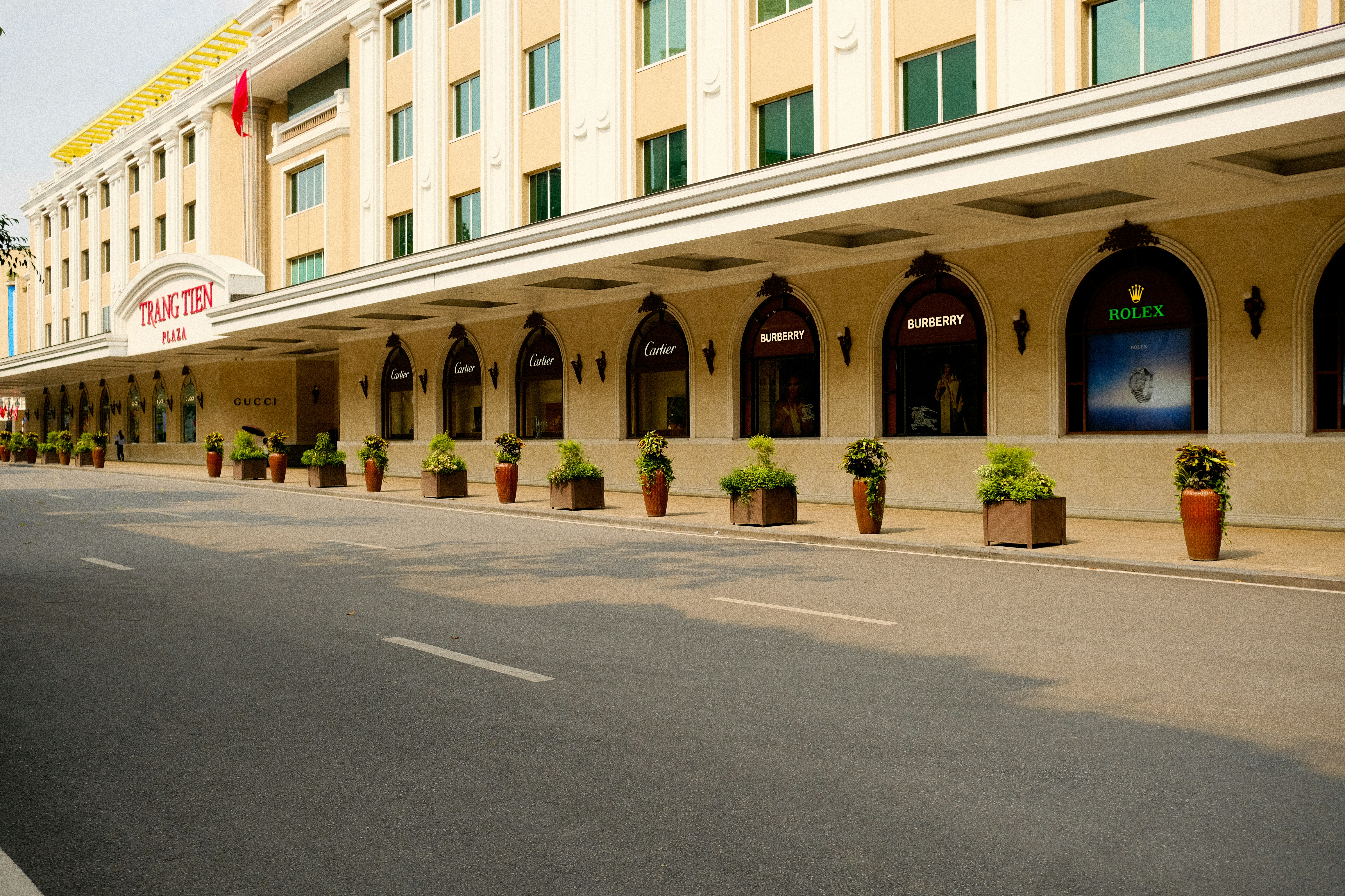 A large building with storefronts and a road.