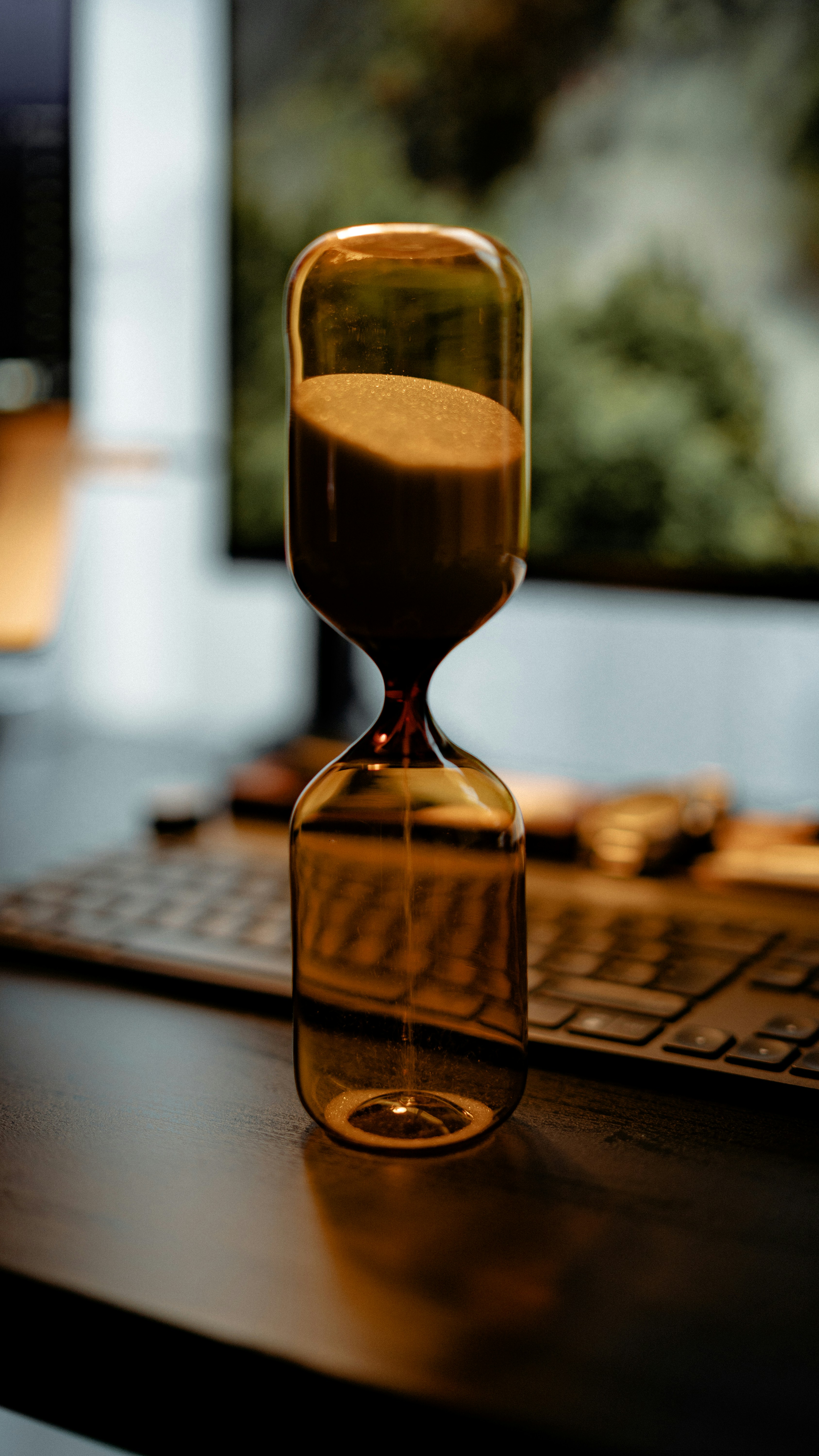 An hourglass on a desk with blurred background. photo – Free Hourglass ...