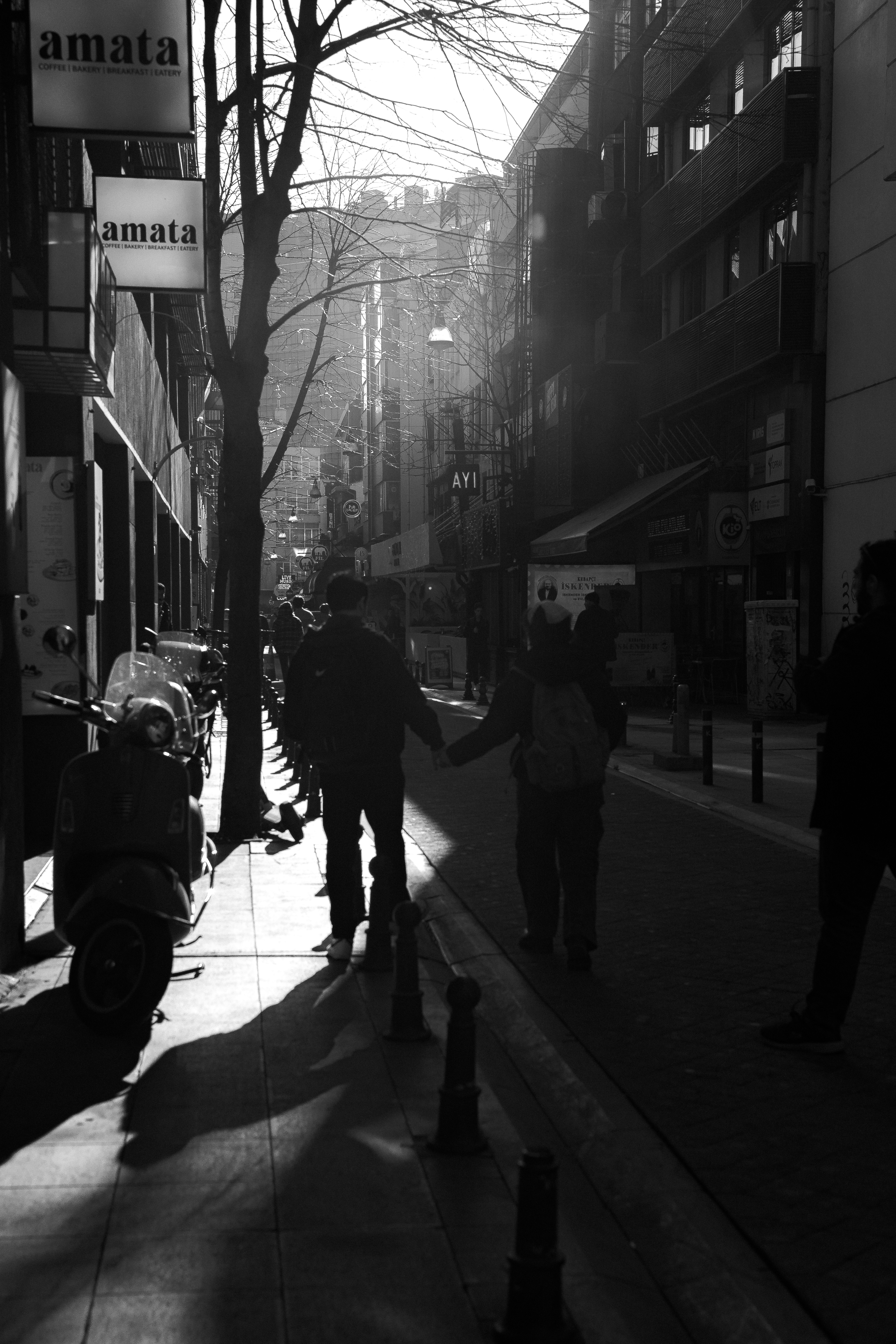 As a 3D artist and designer, I sometimes find myself drawn to photography and living in Istanbul, with all its beauty, has turned that impulse into something truly special. I don’t consider myself a photographer, but I do allow myself to press the shutter when it feels like the right moment to capture something. Sometimes it’s a fleeting scene on the street, something that only asks for my presence and attention. Other times, it’s an image I’ve carefully constructed with intention and patience. | People walk down a sun-drenched city street.