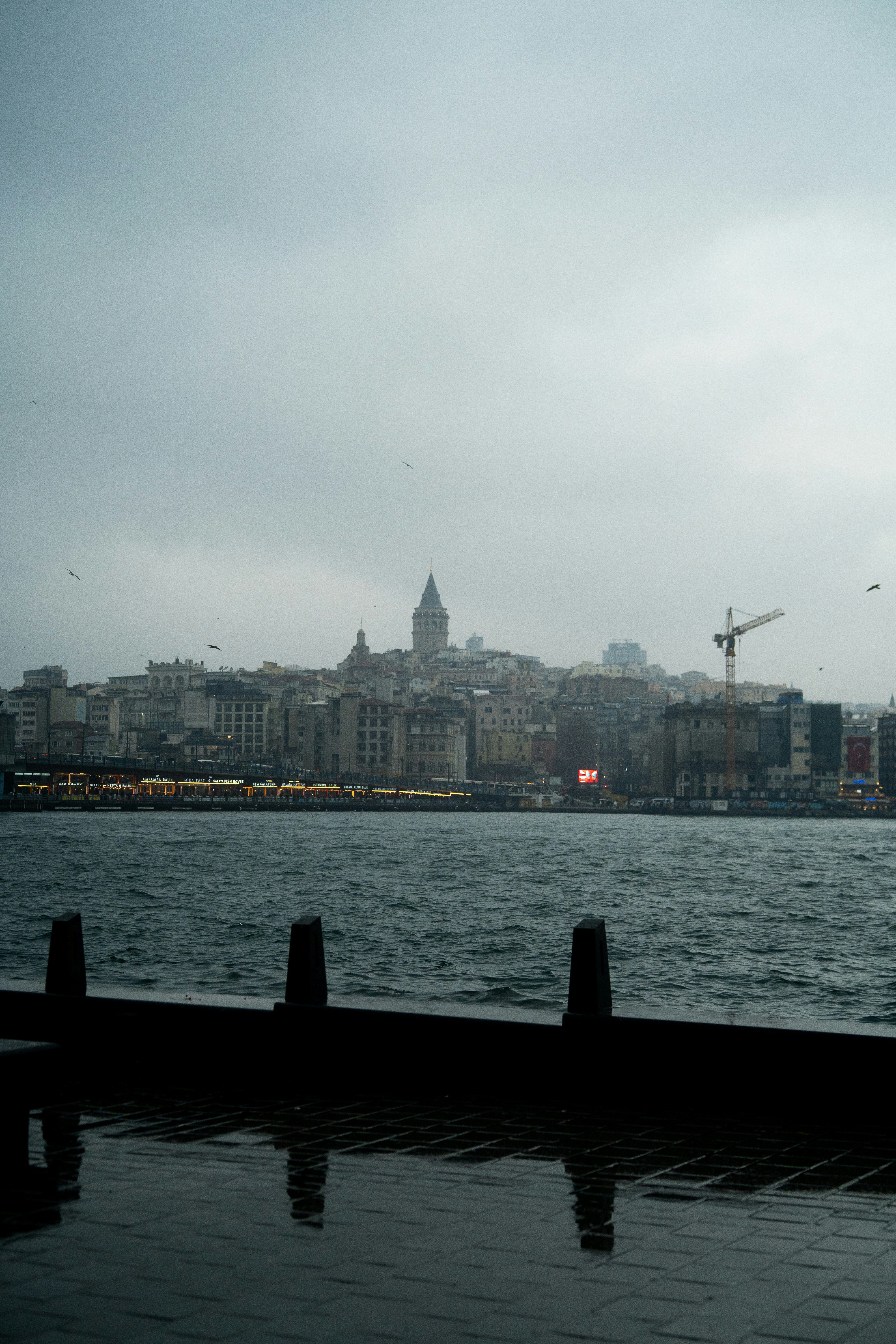 As a 3D artist and designer, I sometimes find myself drawn to photography and living in Istanbul, with all its beauty, has turned that impulse into something truly special. I don’t consider myself a photographer, but I do allow myself to press the shutter when it feels like the right moment to capture something. Sometimes it’s a fleeting scene on the street, something that only asks for my presence and attention. Other times, it’s an image I’ve carefully constructed with intention and patience. | A rainy day view of a city skyline.