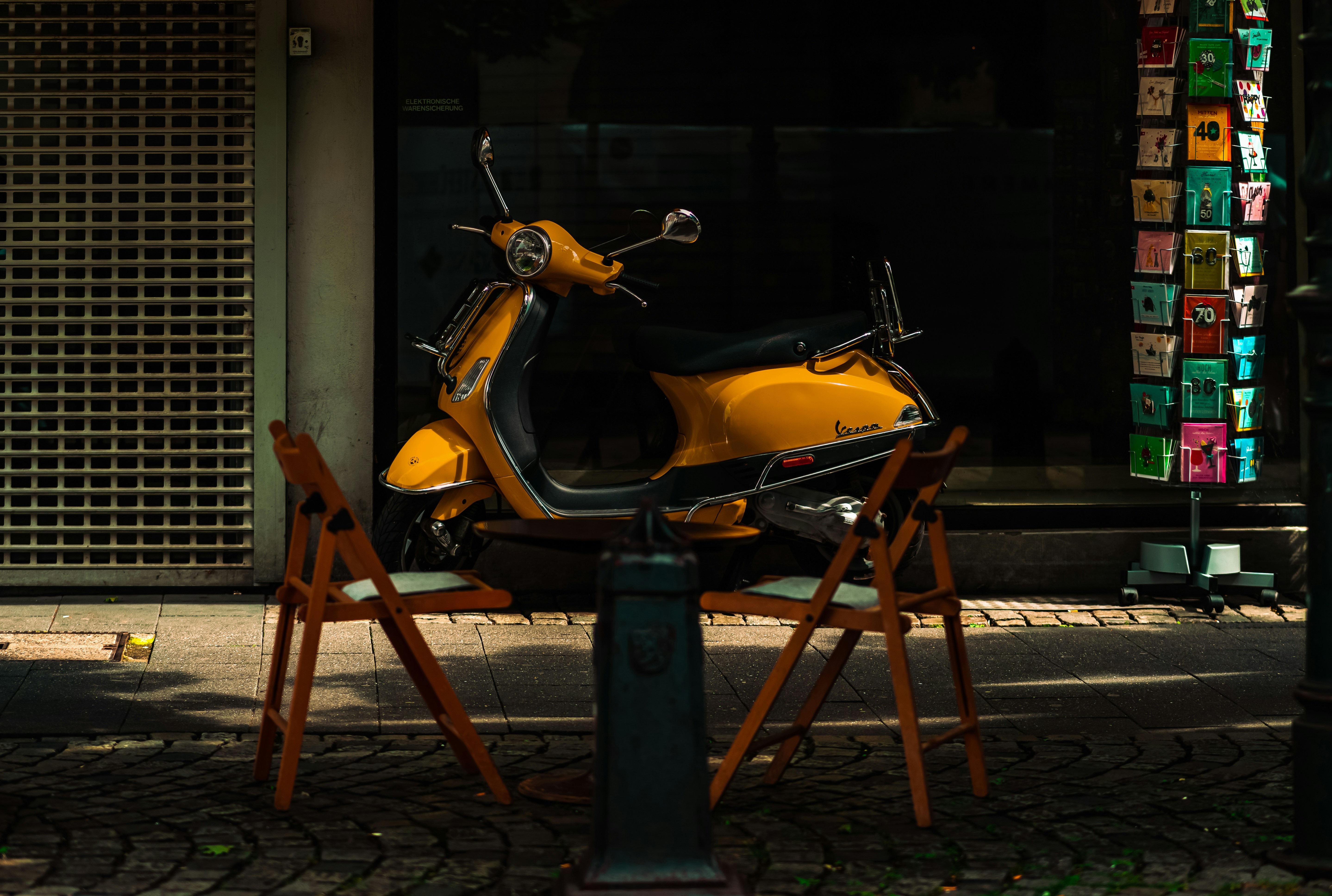 A yellow scooter rests between chairs.