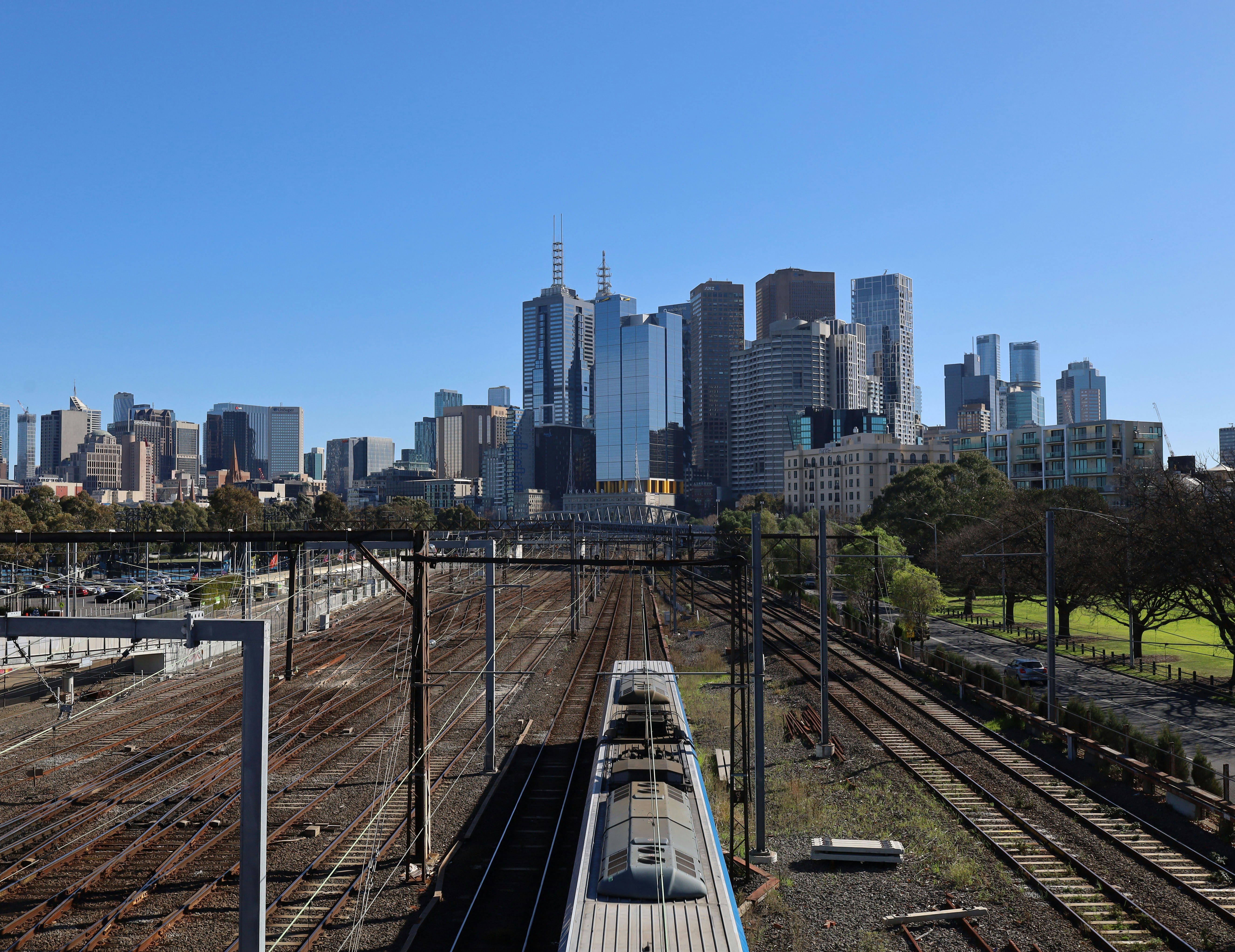 Train tracks lead to a city skyline.