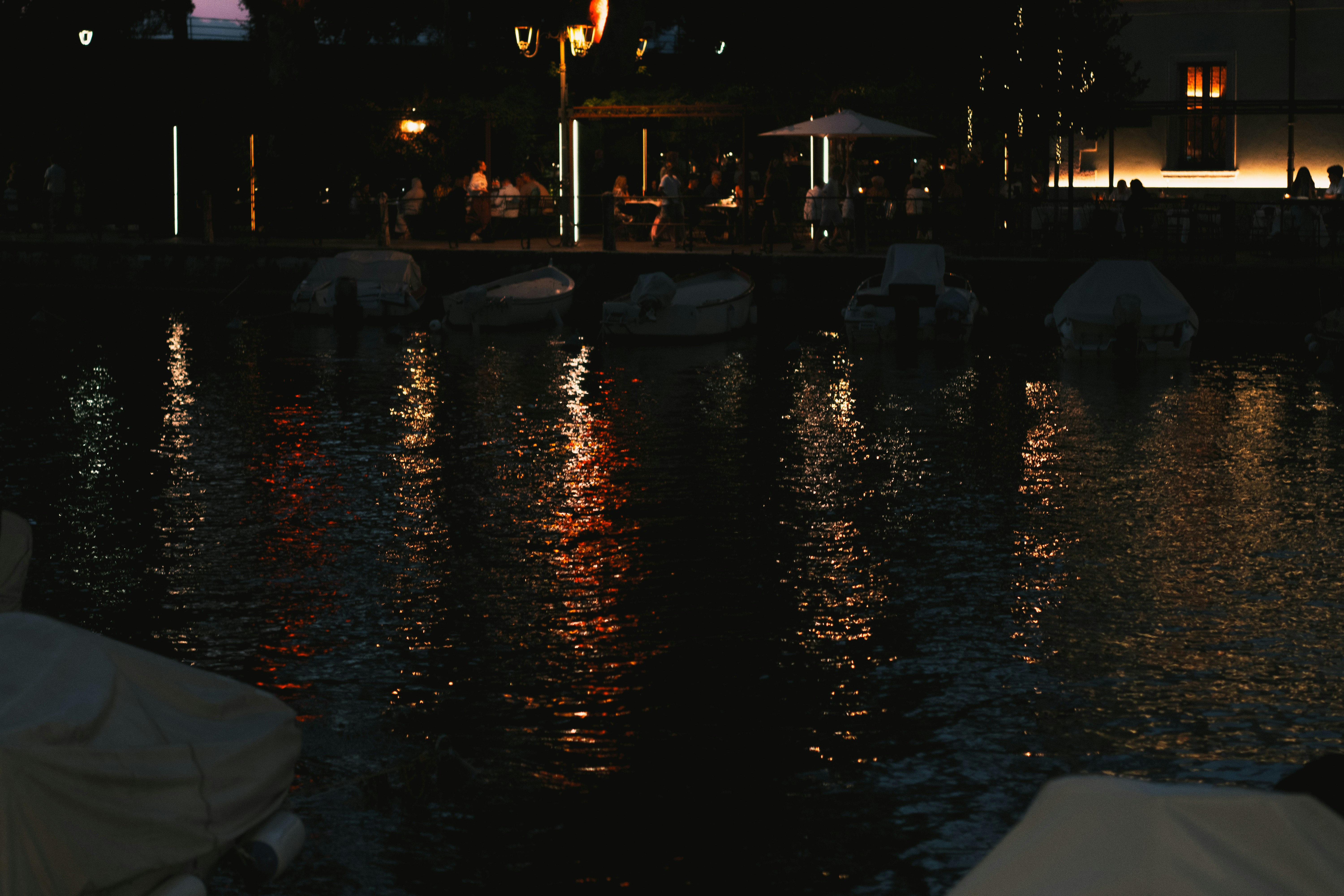 Nighttime lights reflect in rippling water.