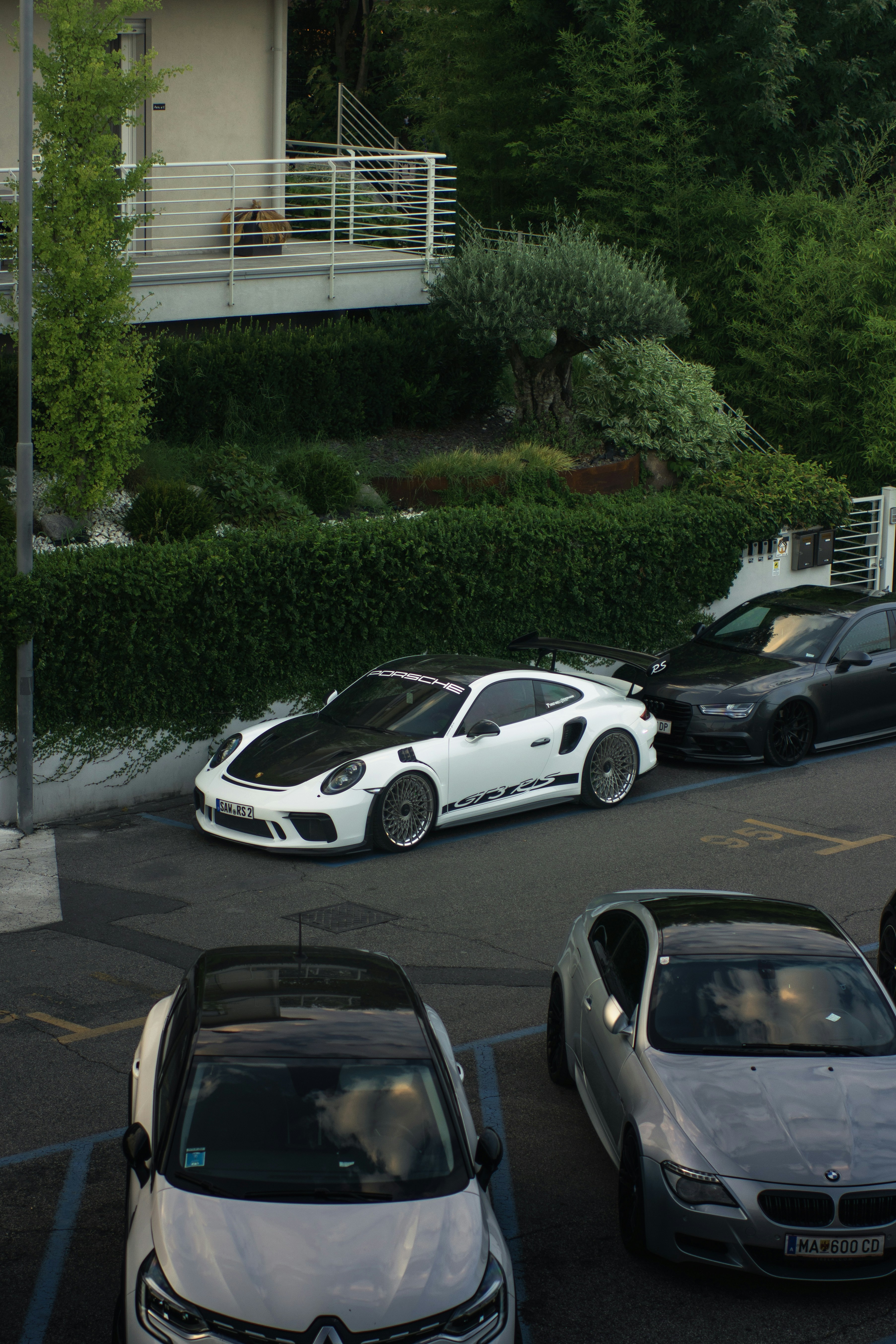 A high-performance sports car parked amidst regular vehicles, showcasing its distinctive design and racing features.