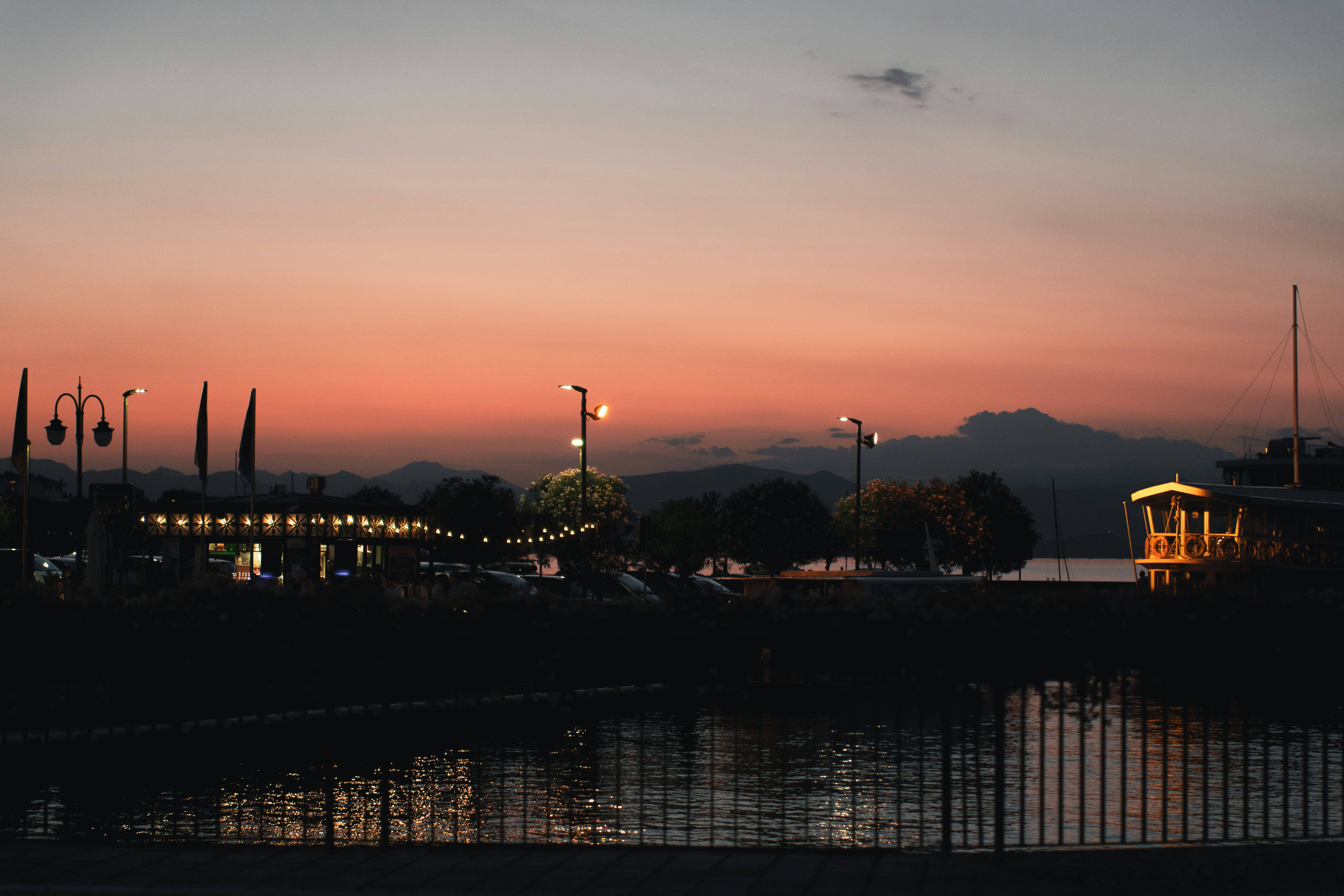 Sunset over a body of water with lights.