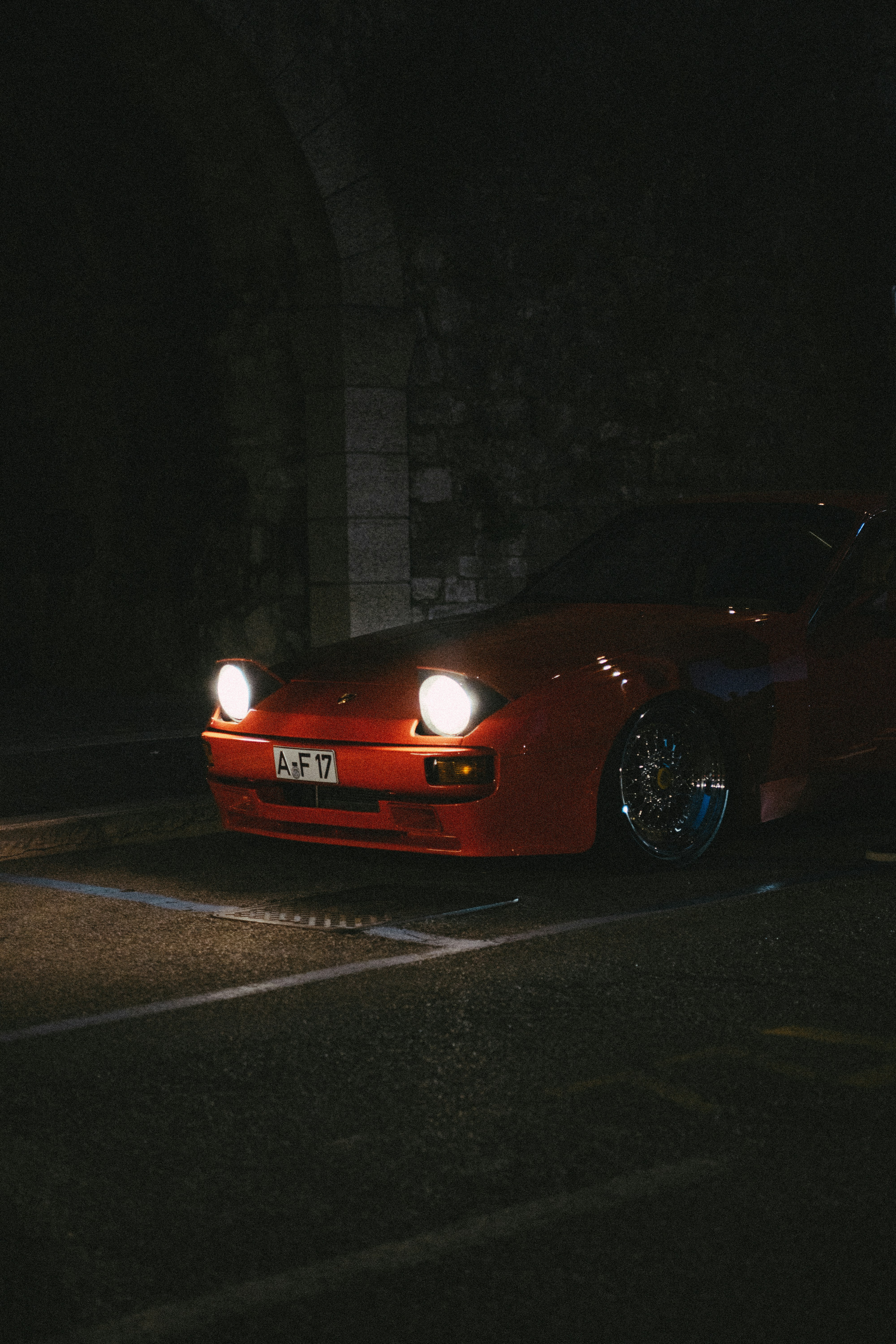 Nighttime Elegance: A Red Classic Under the Archway