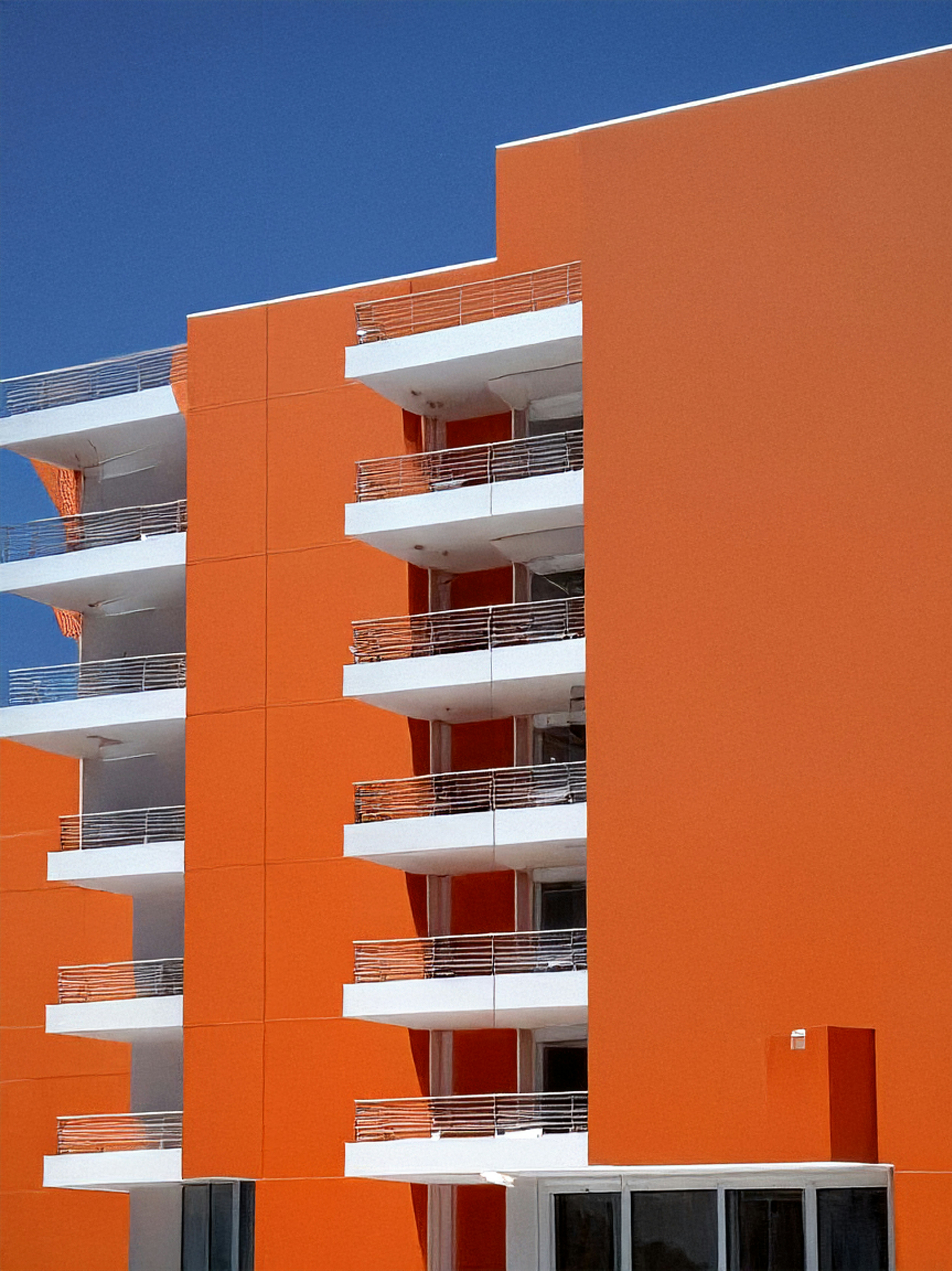 Bright orange building with white balconies. photo – Free City Image on ...