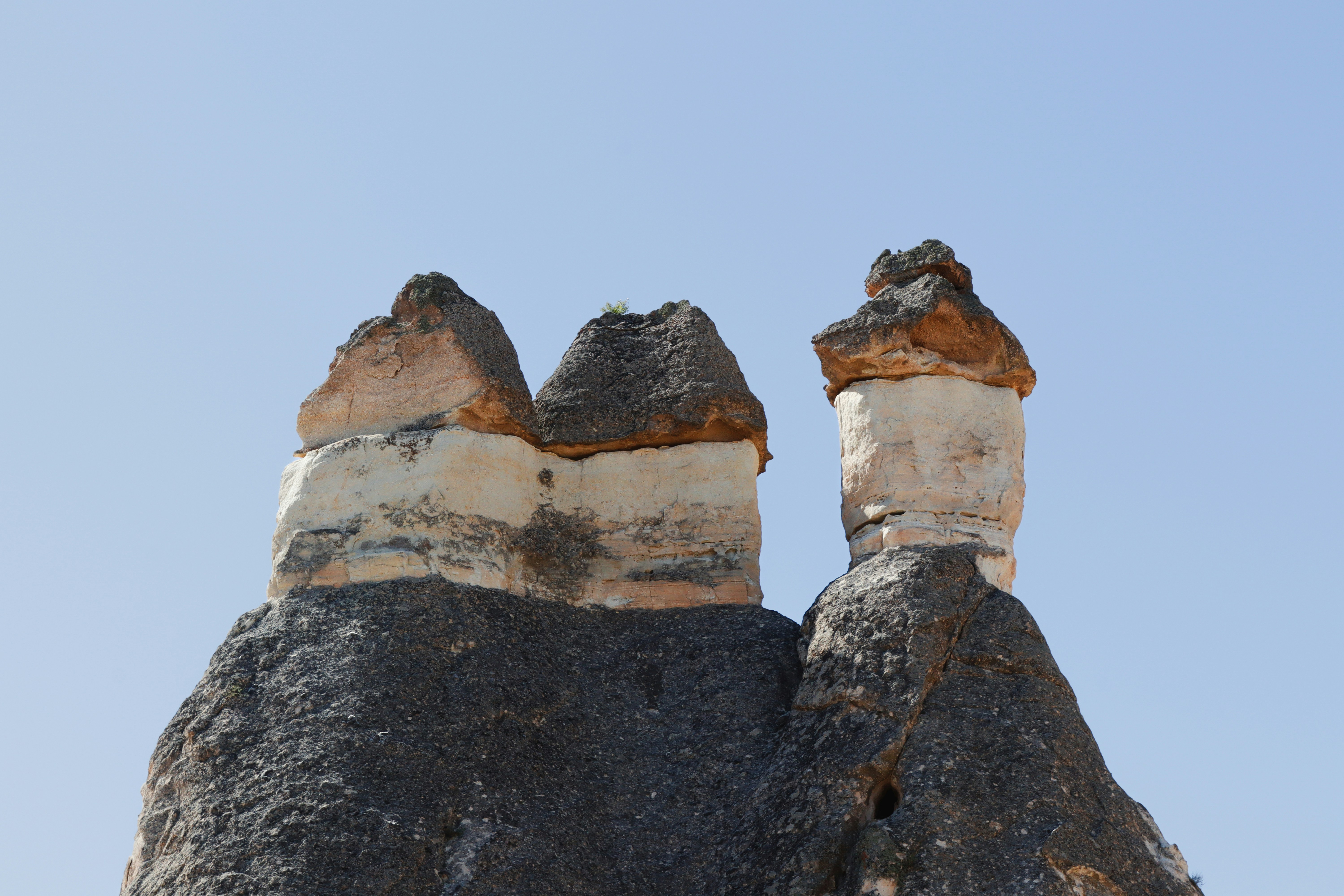 Captivating Fairy Chimneys in Cappadocia | Fairy chimneys stand tall under a clear blue sky.