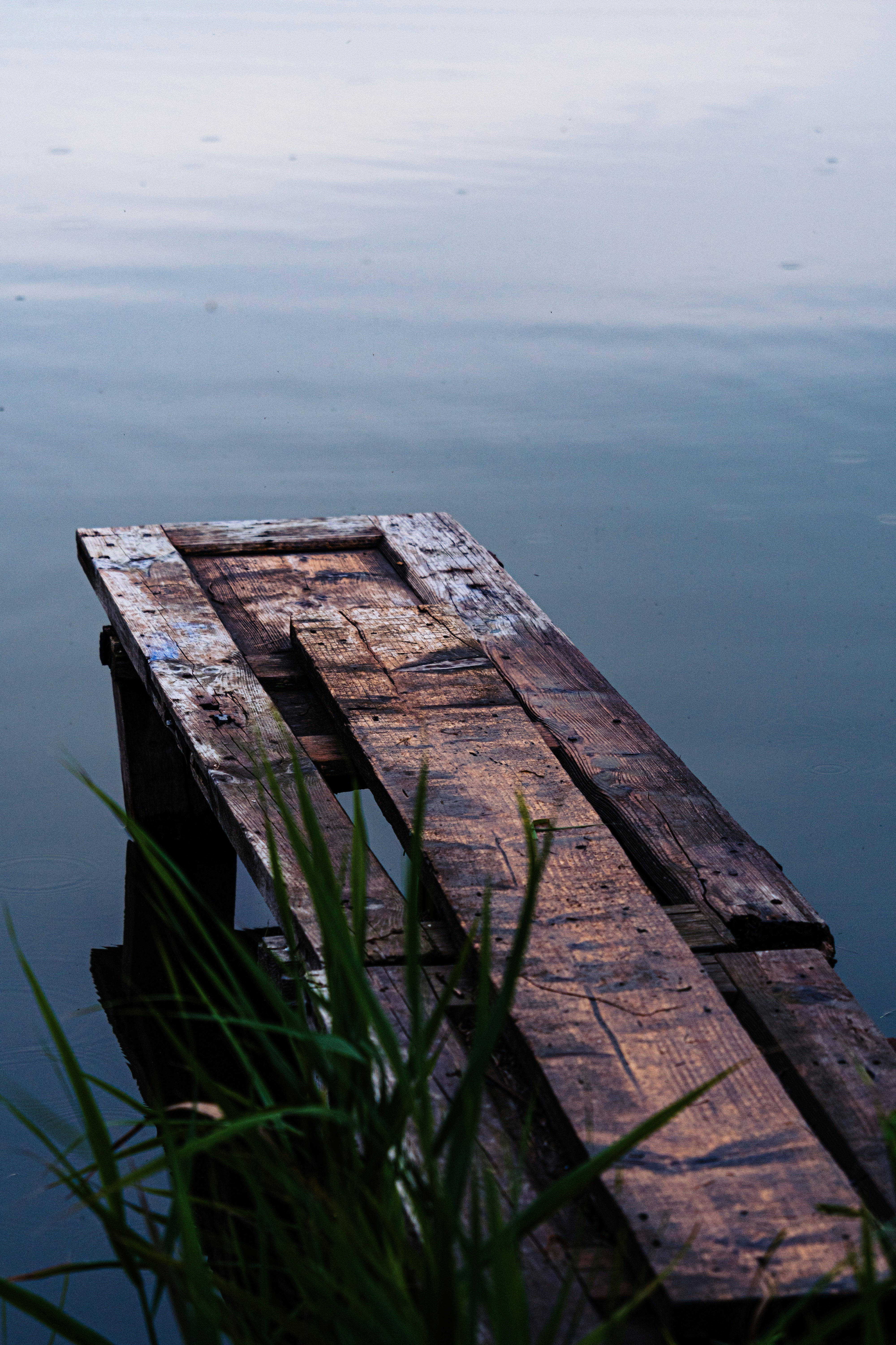 Weathered wooden dock extends into calm water.