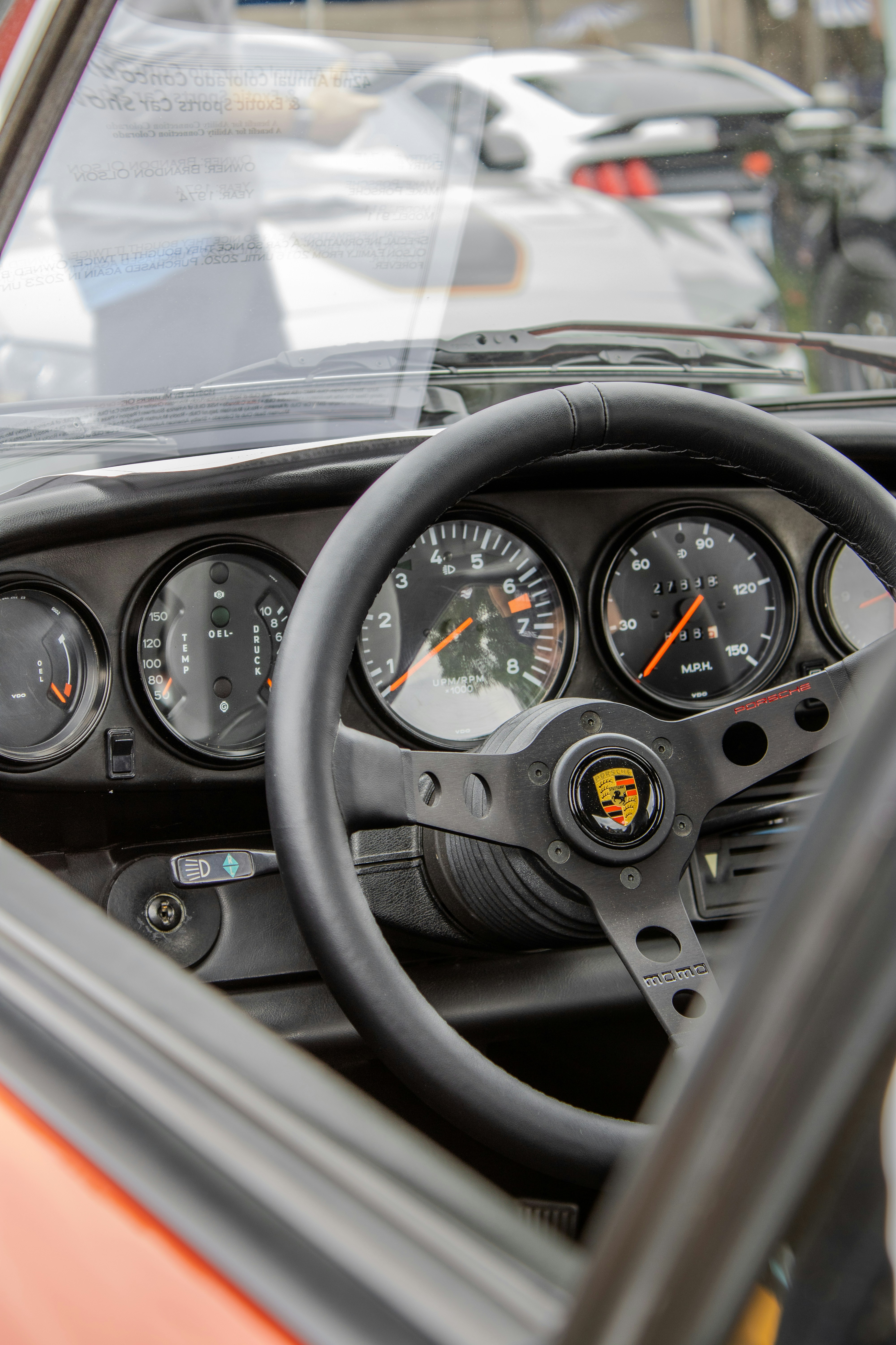 Dashboard view of a classic Porsche, showcasing intricate gauges and steering wheel design.