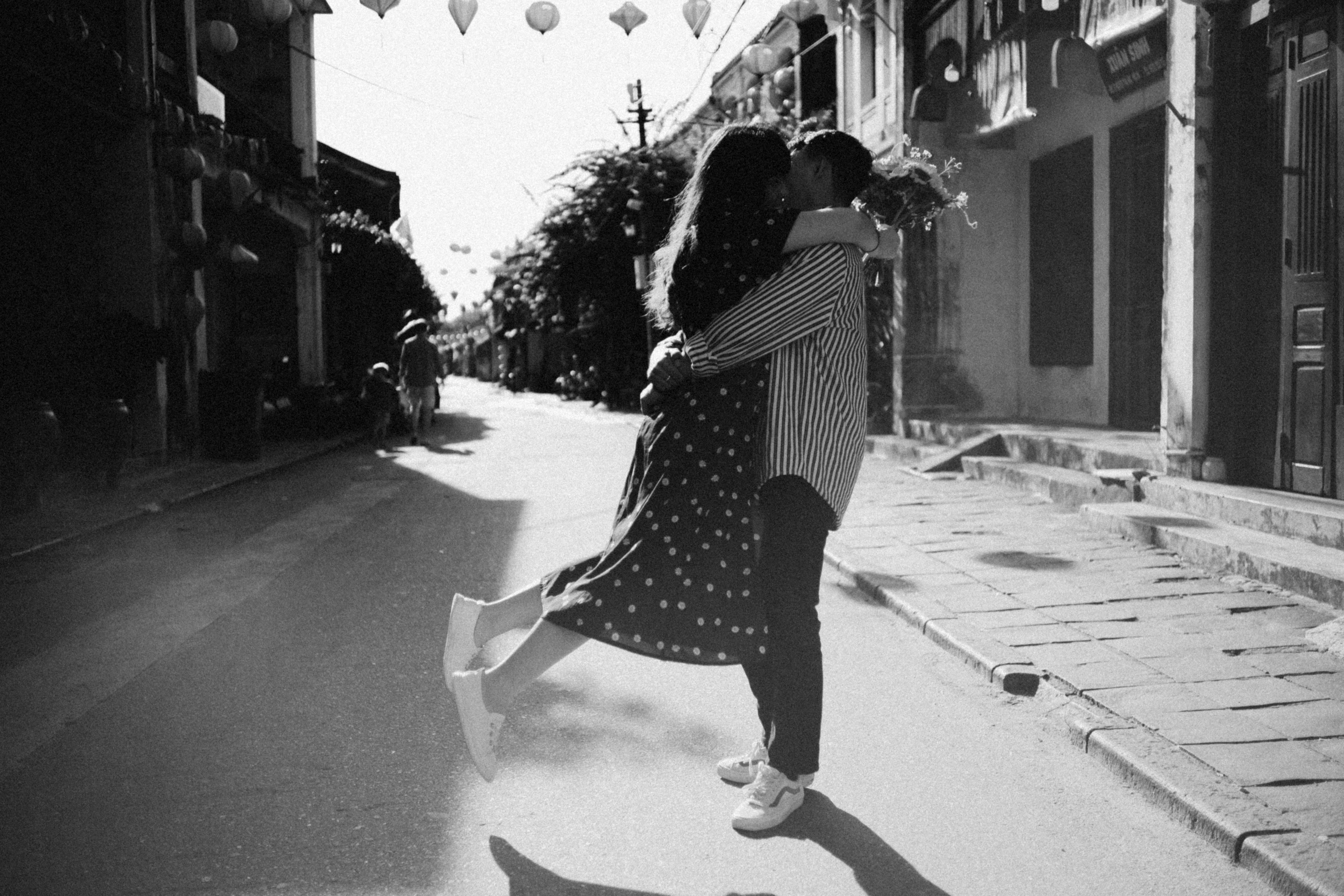 A couple shares a loving embrace in the street.