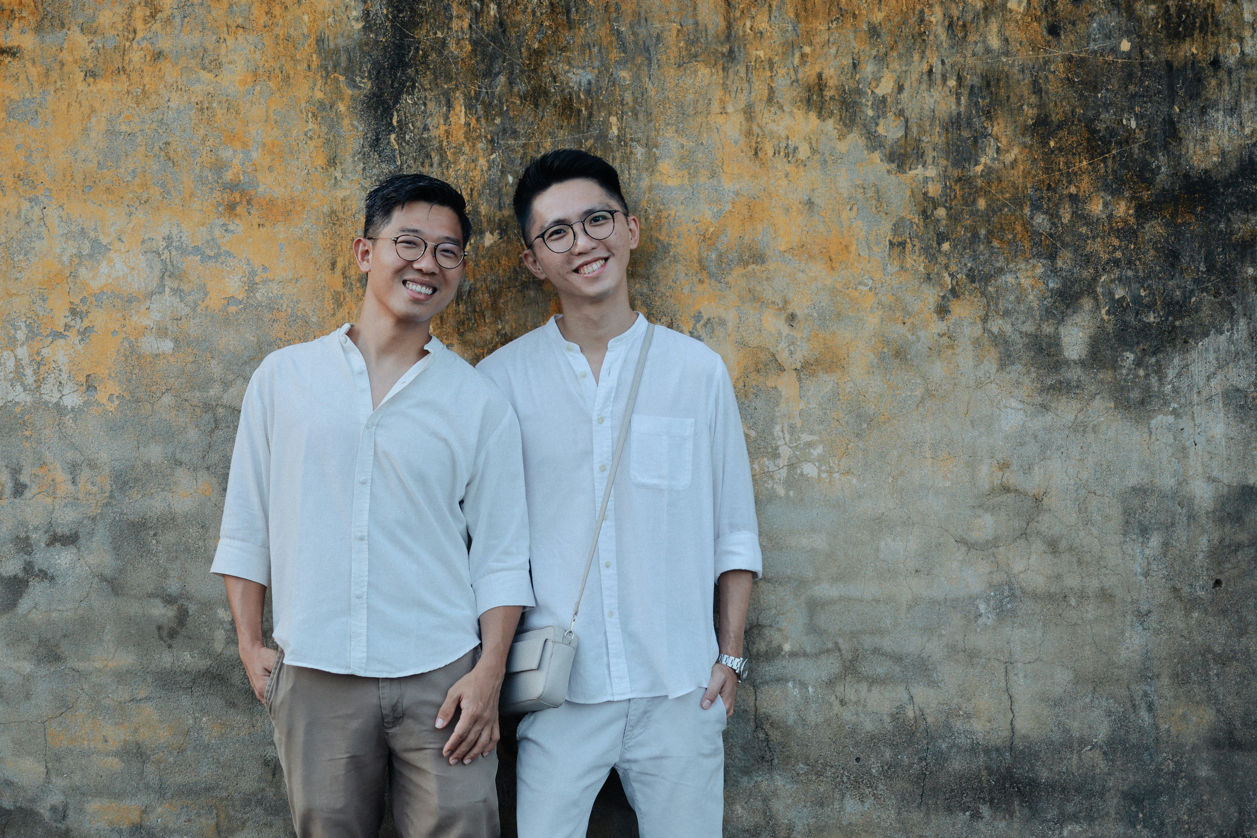Two men smile and lean against a wall. photo – Free Portrait Image on ...