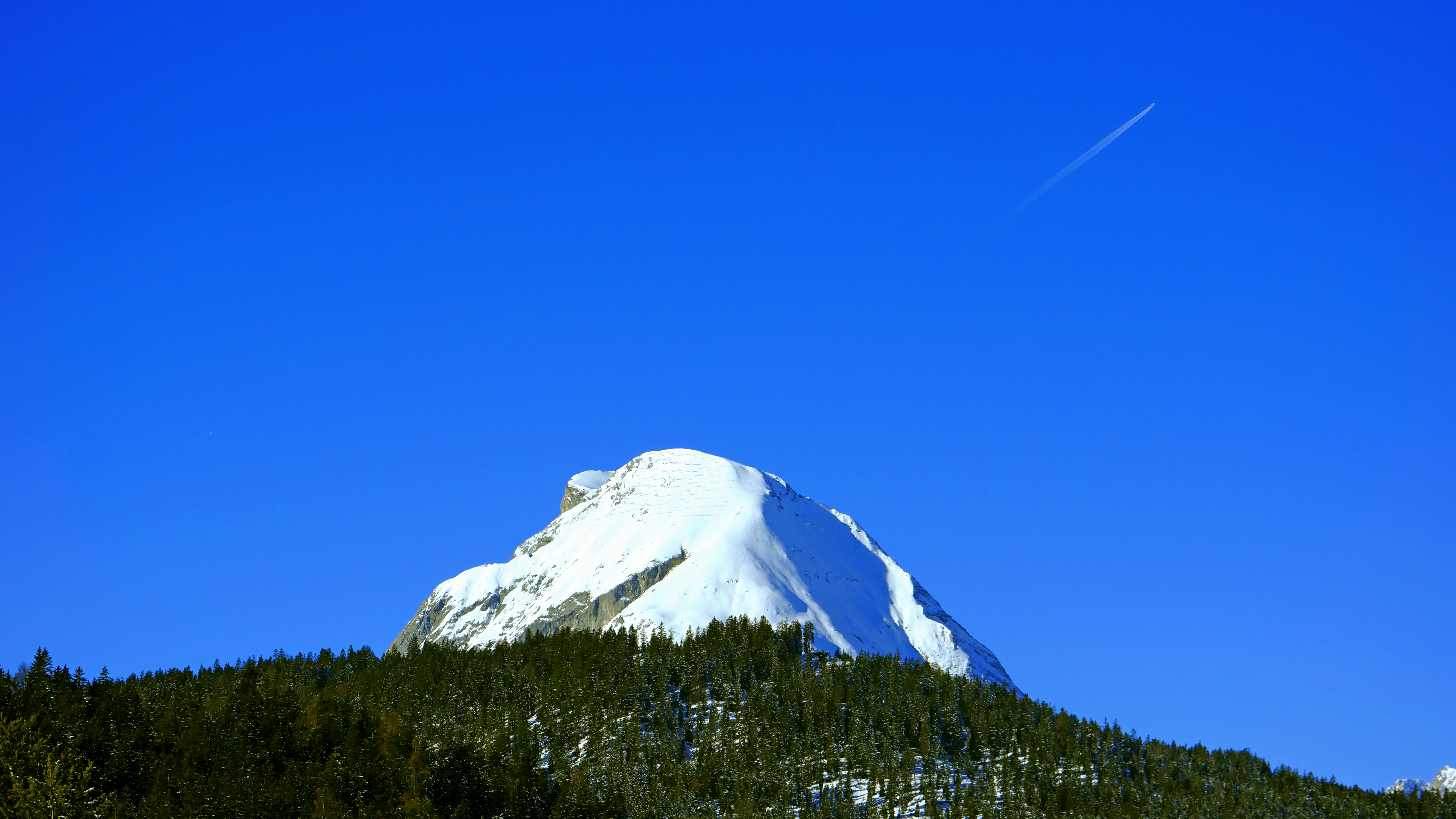 Snowy mountain peak under a clear, blue sky.