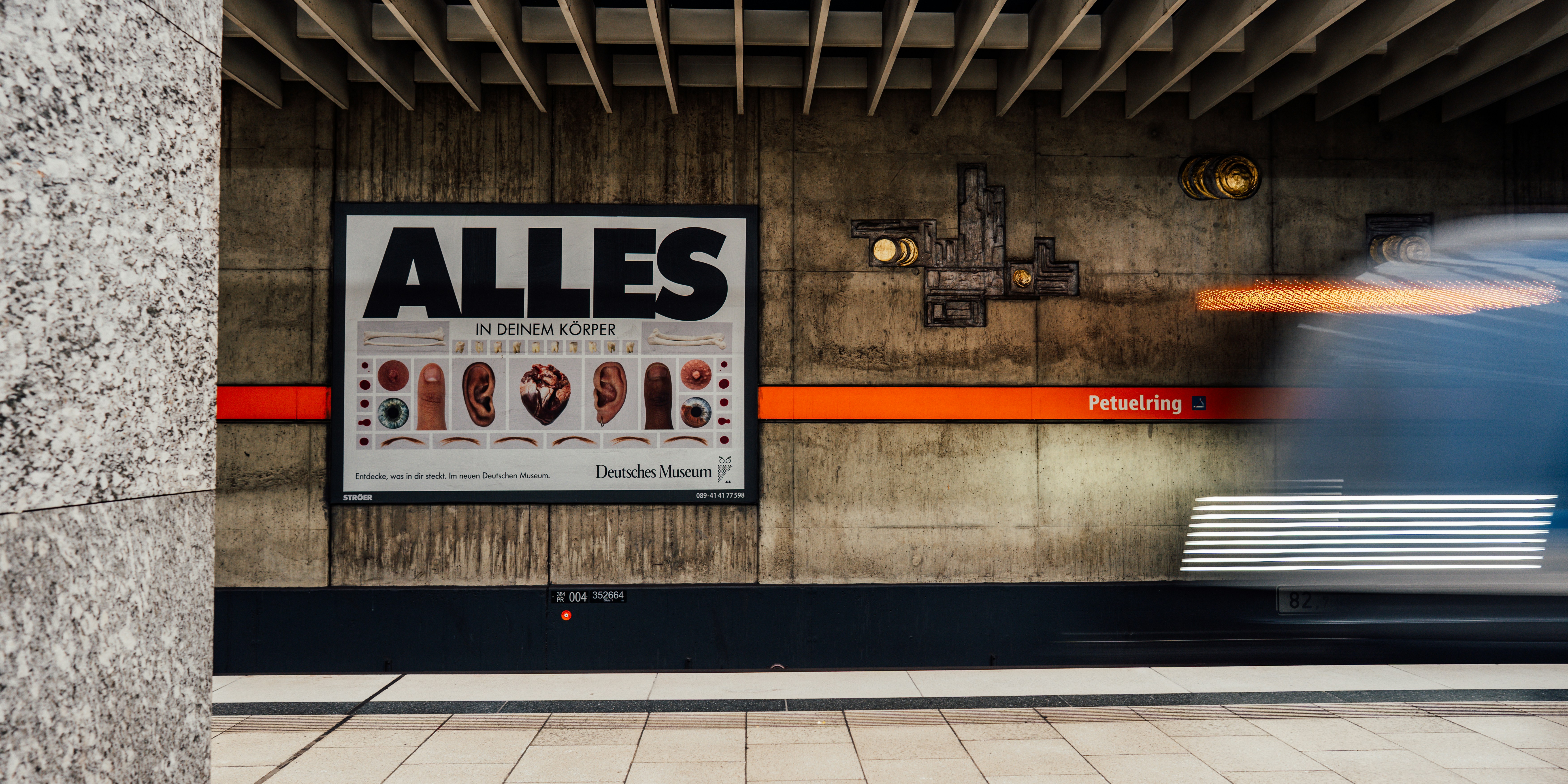 A blurry train passes a sign that reads "alles".