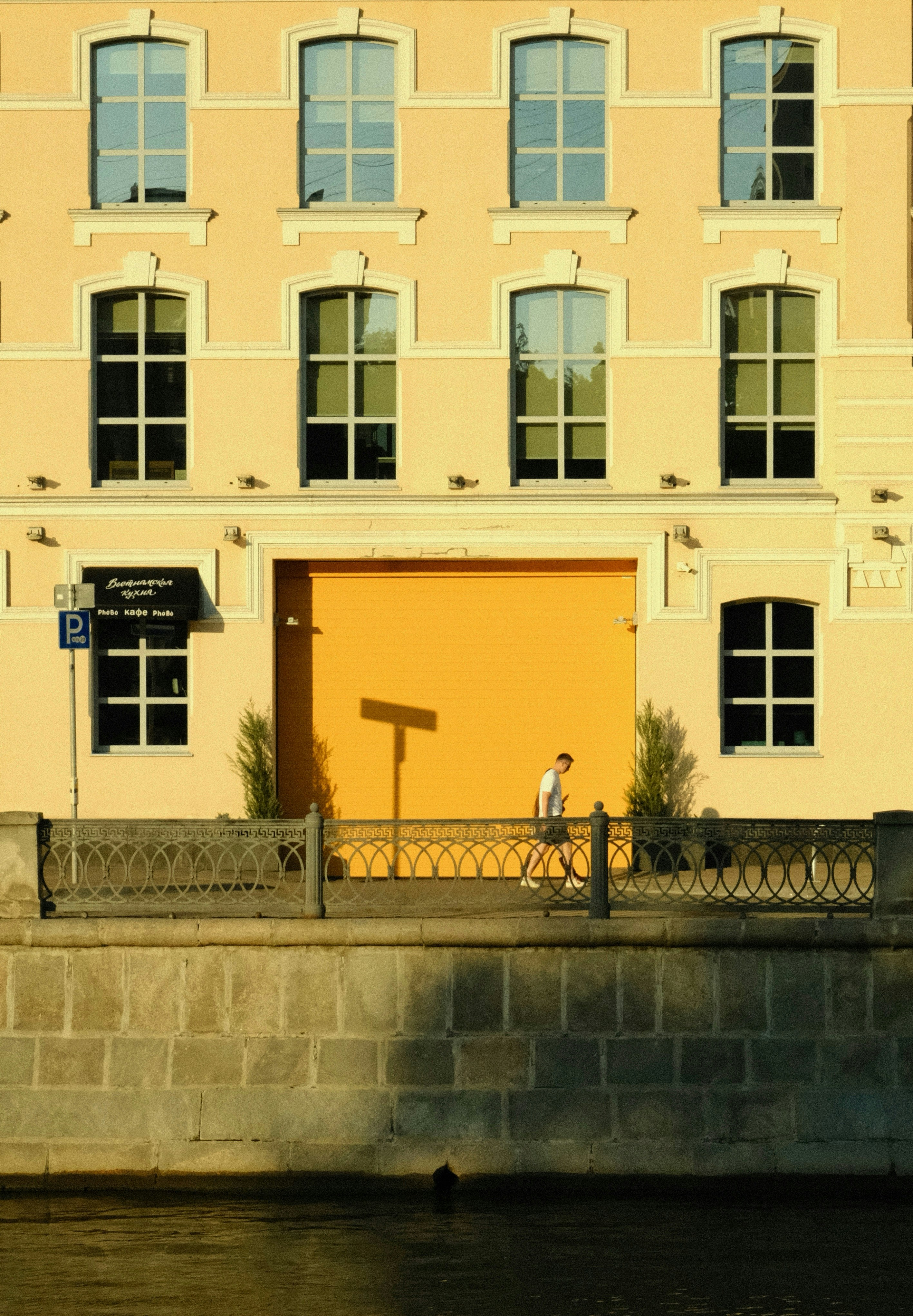 A person walks along a riverside.