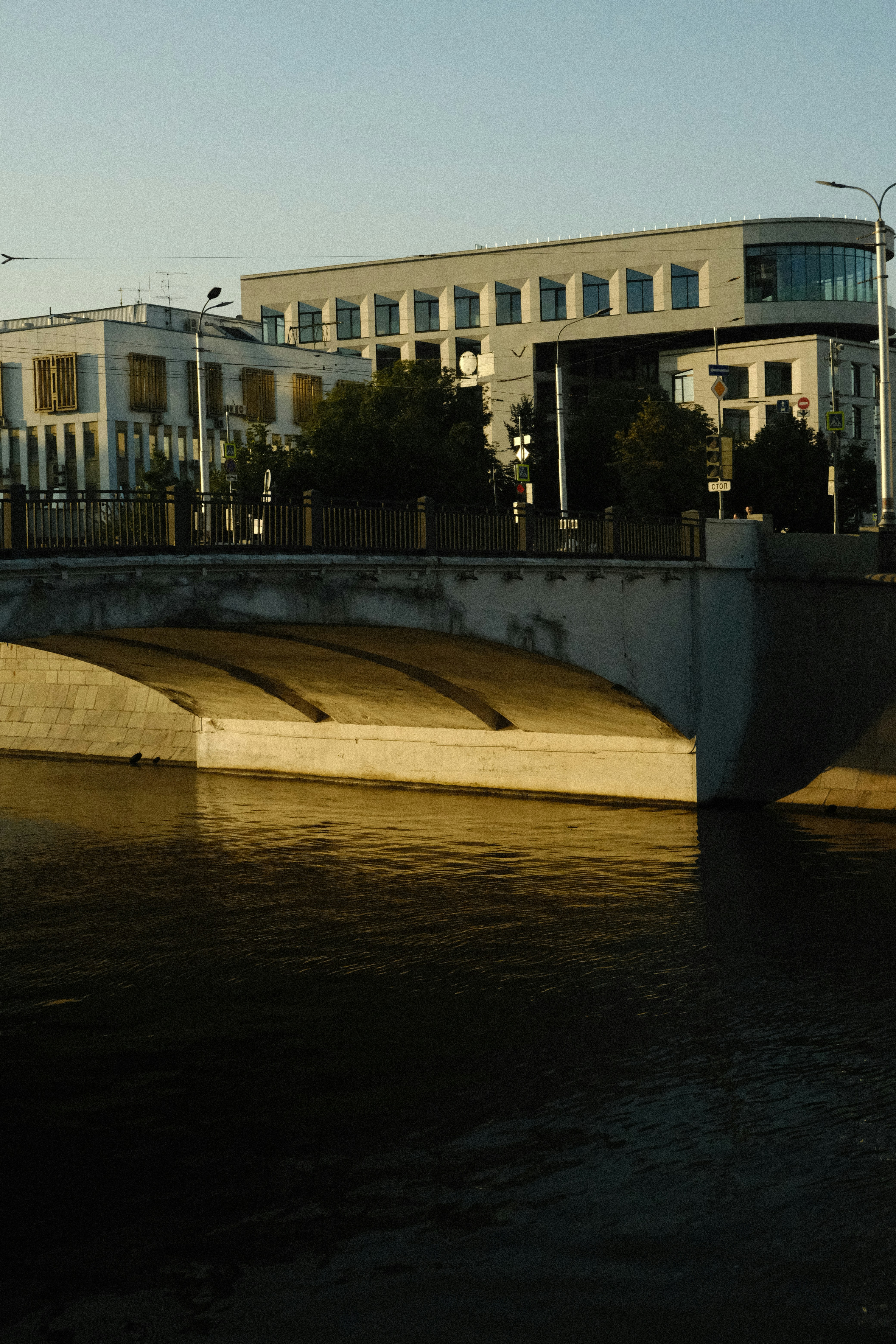 A bridge over water, leading to buildings.