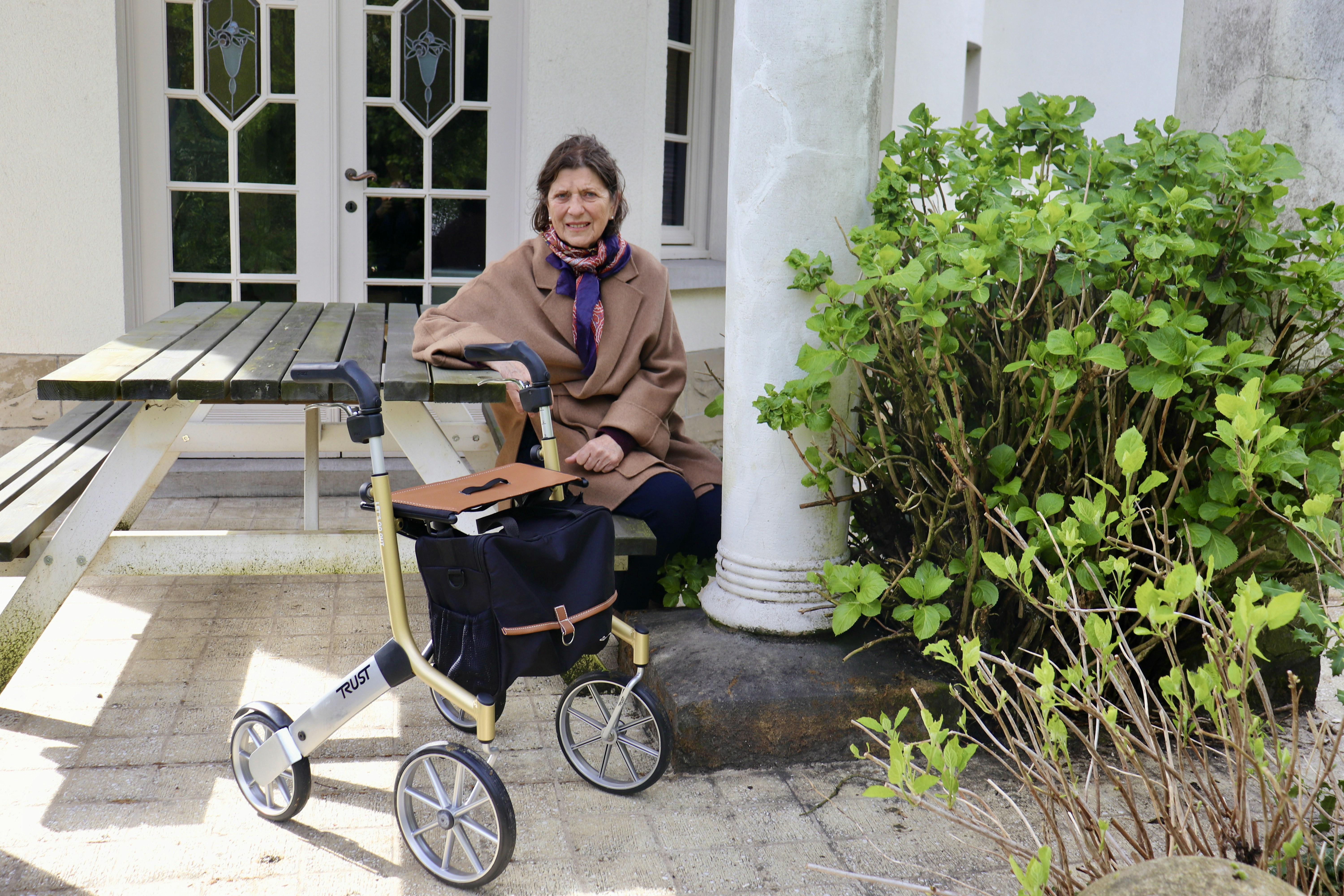 Woman poses with a rollator outside a building. photo – Free Rollator ...