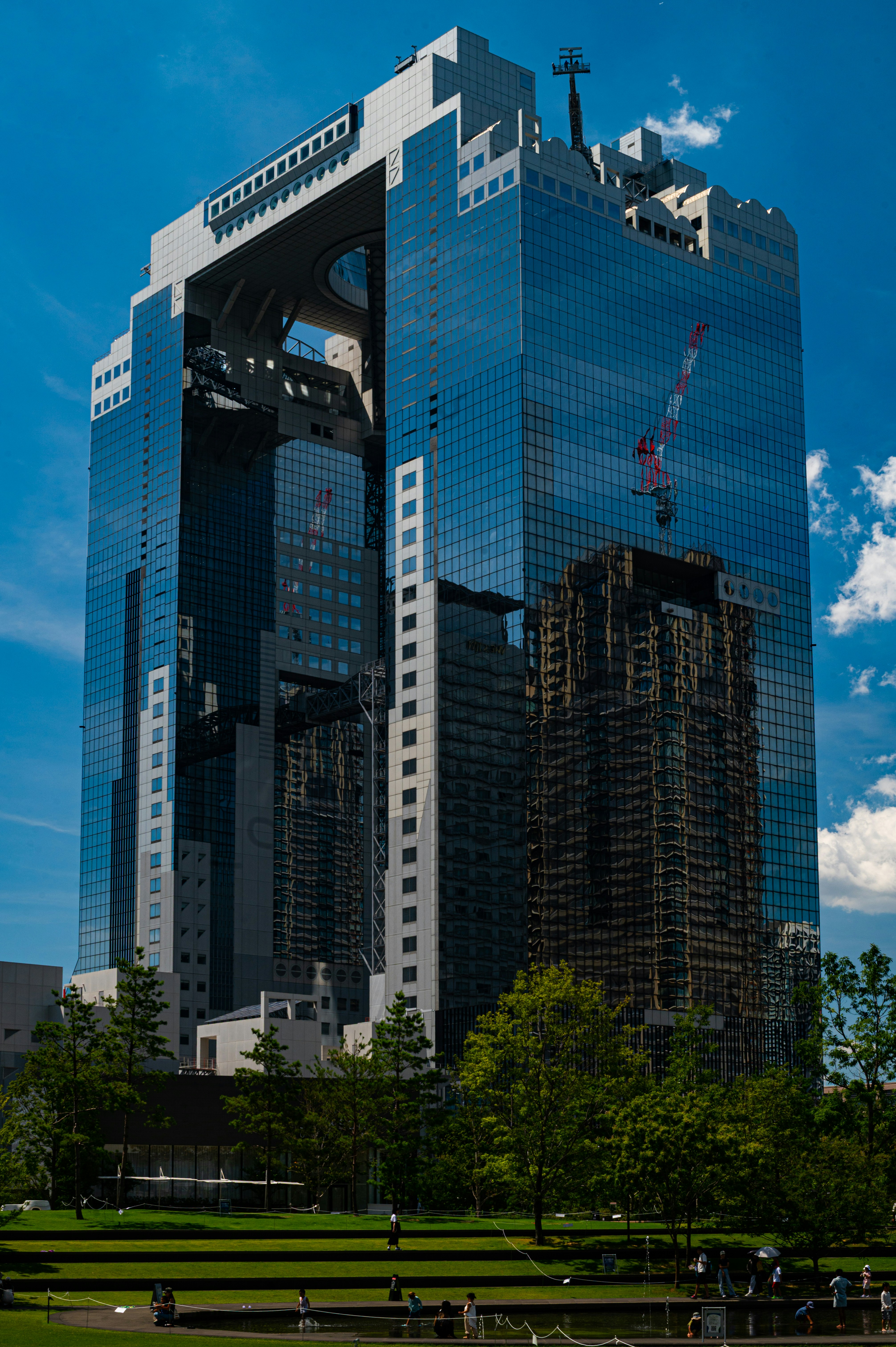 A tall, modern building against a bright blue sky.