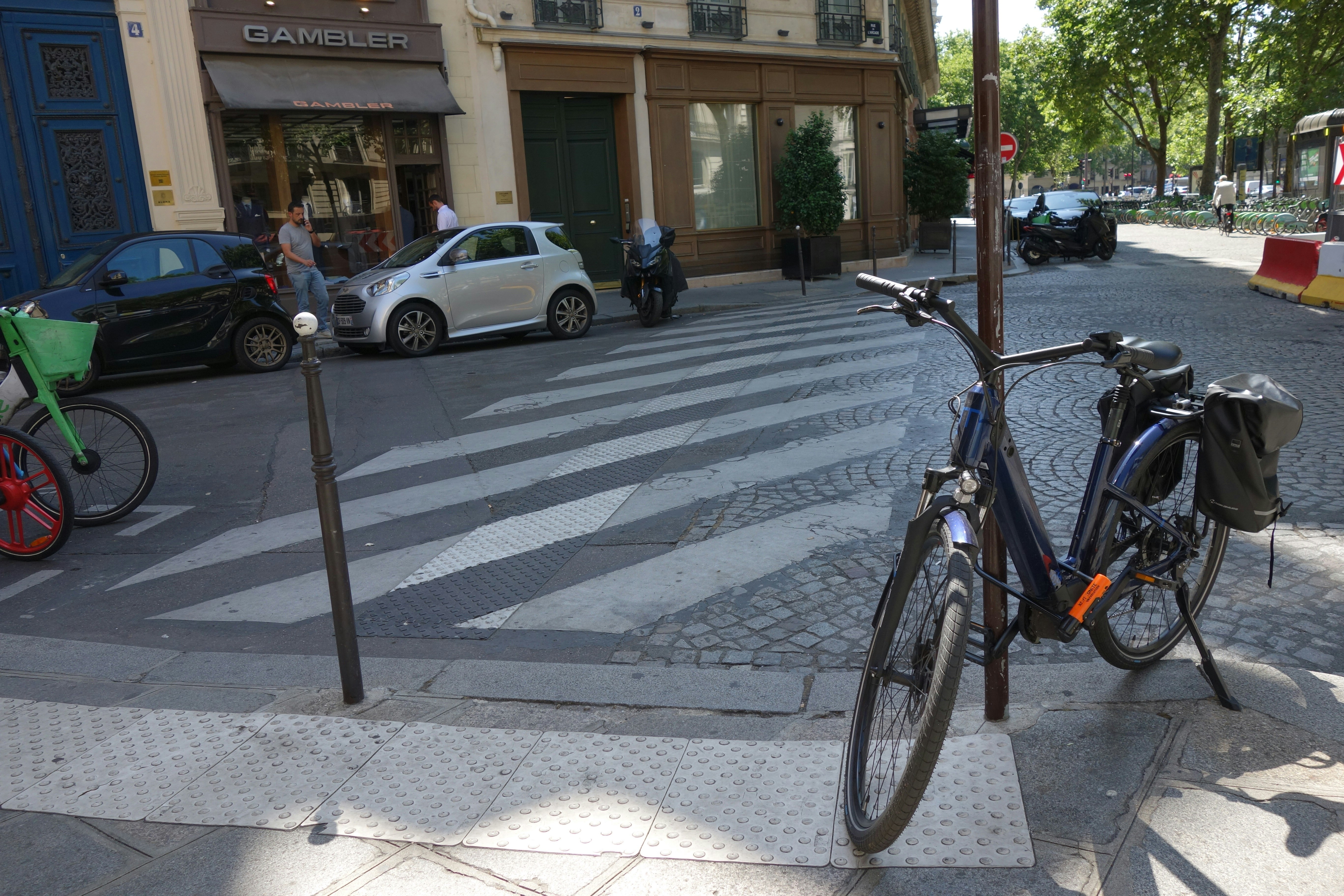 A bike parks on a crosswalk in the city.
