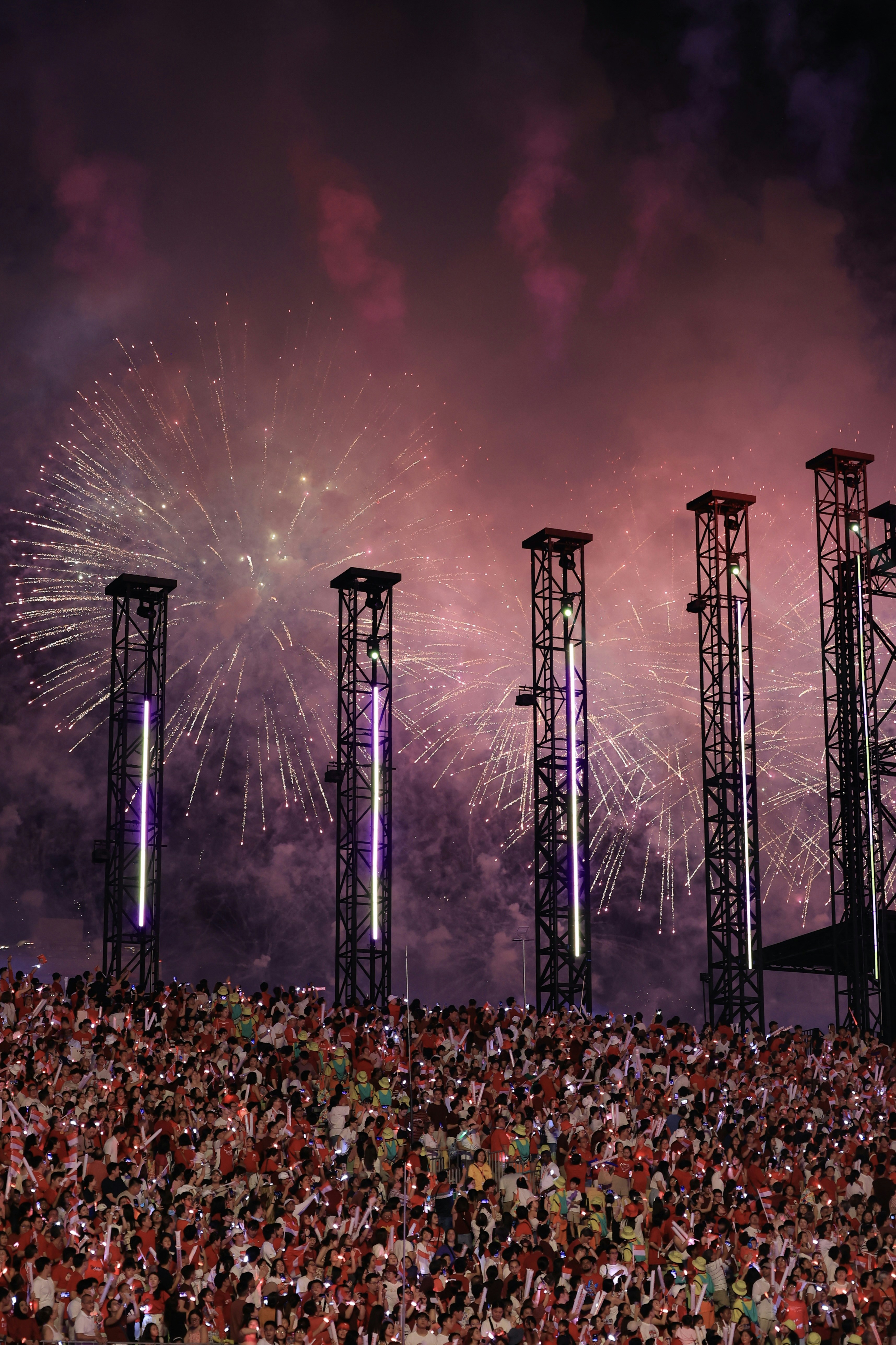 Fireworks illuminate a crowd at a live event.