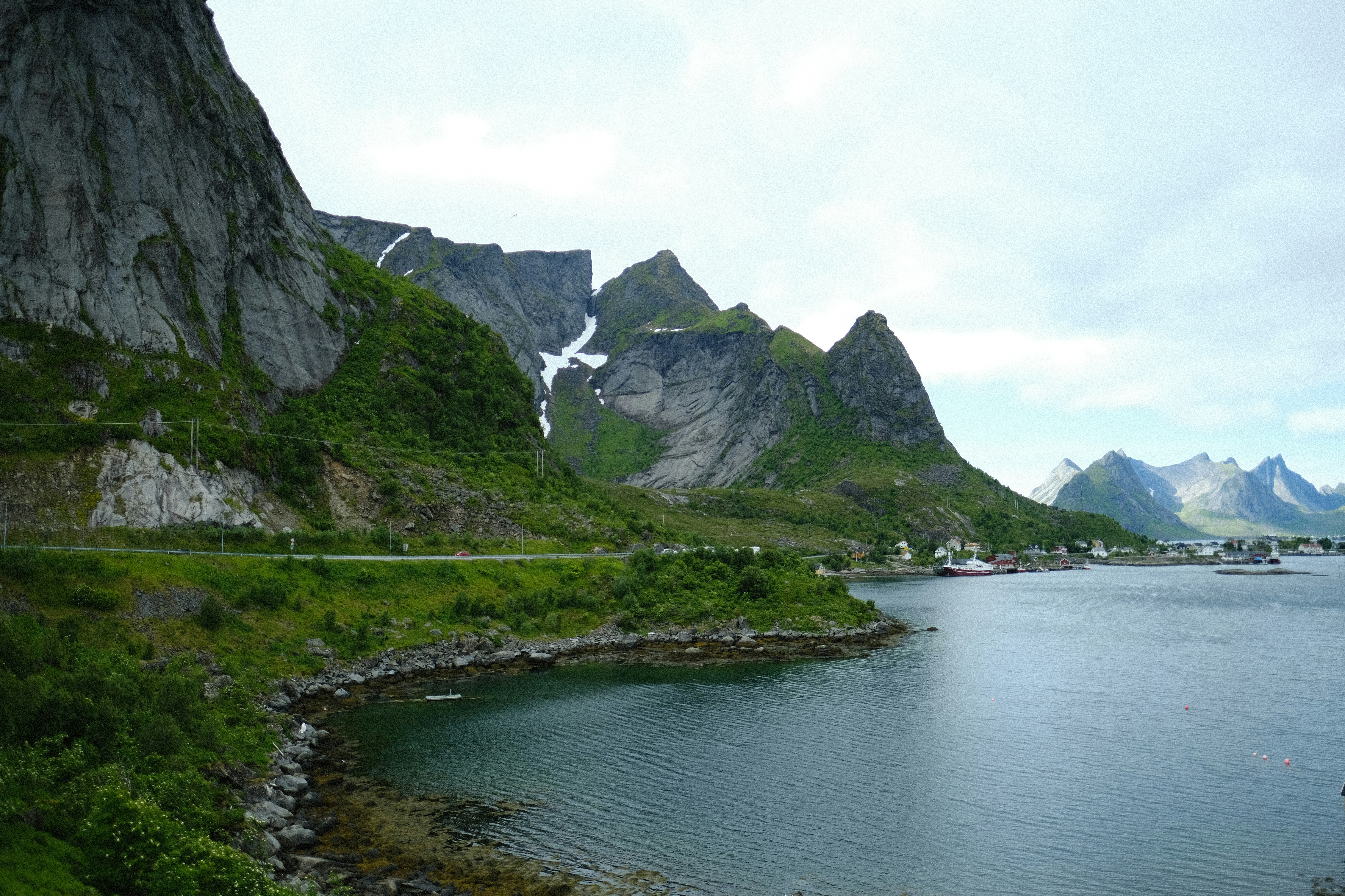 Overlooking Reinebringen area from the bridge of Reine. | Scenic mountains rise above a tranquil bay.