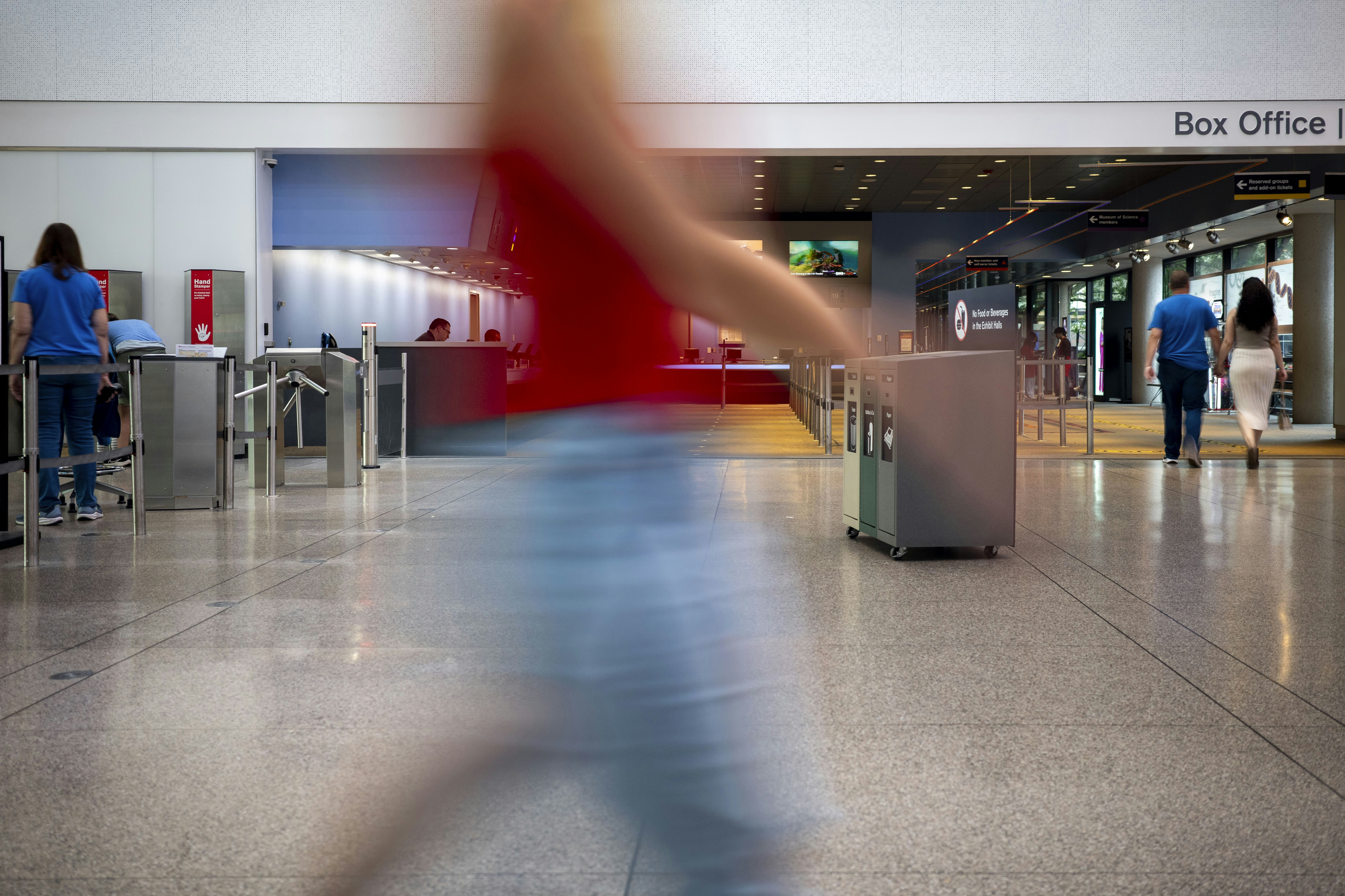 People are blurred in motion at a transit area.