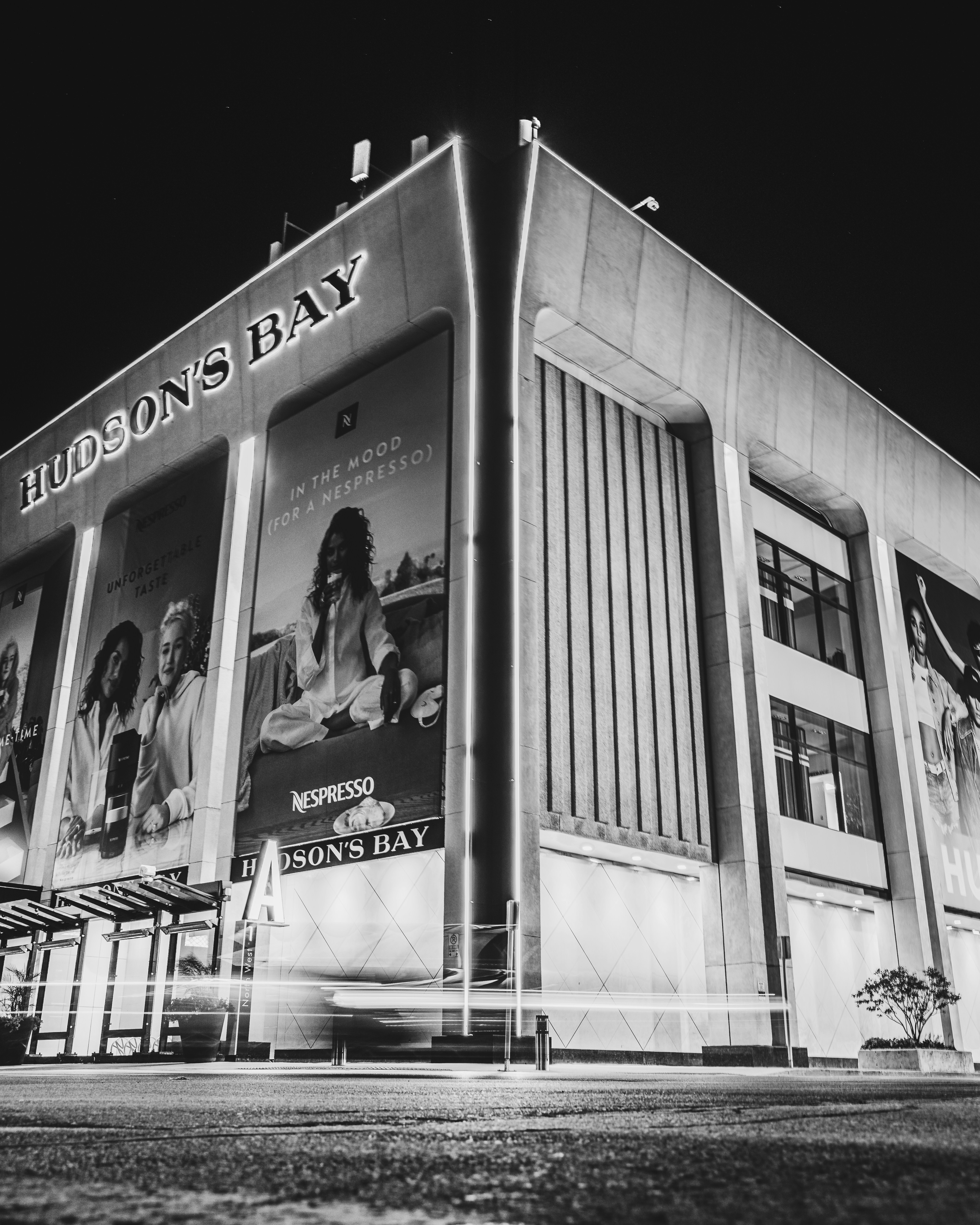 A clothing store at night in black and white. | Hudson's bay store lit up at night.
