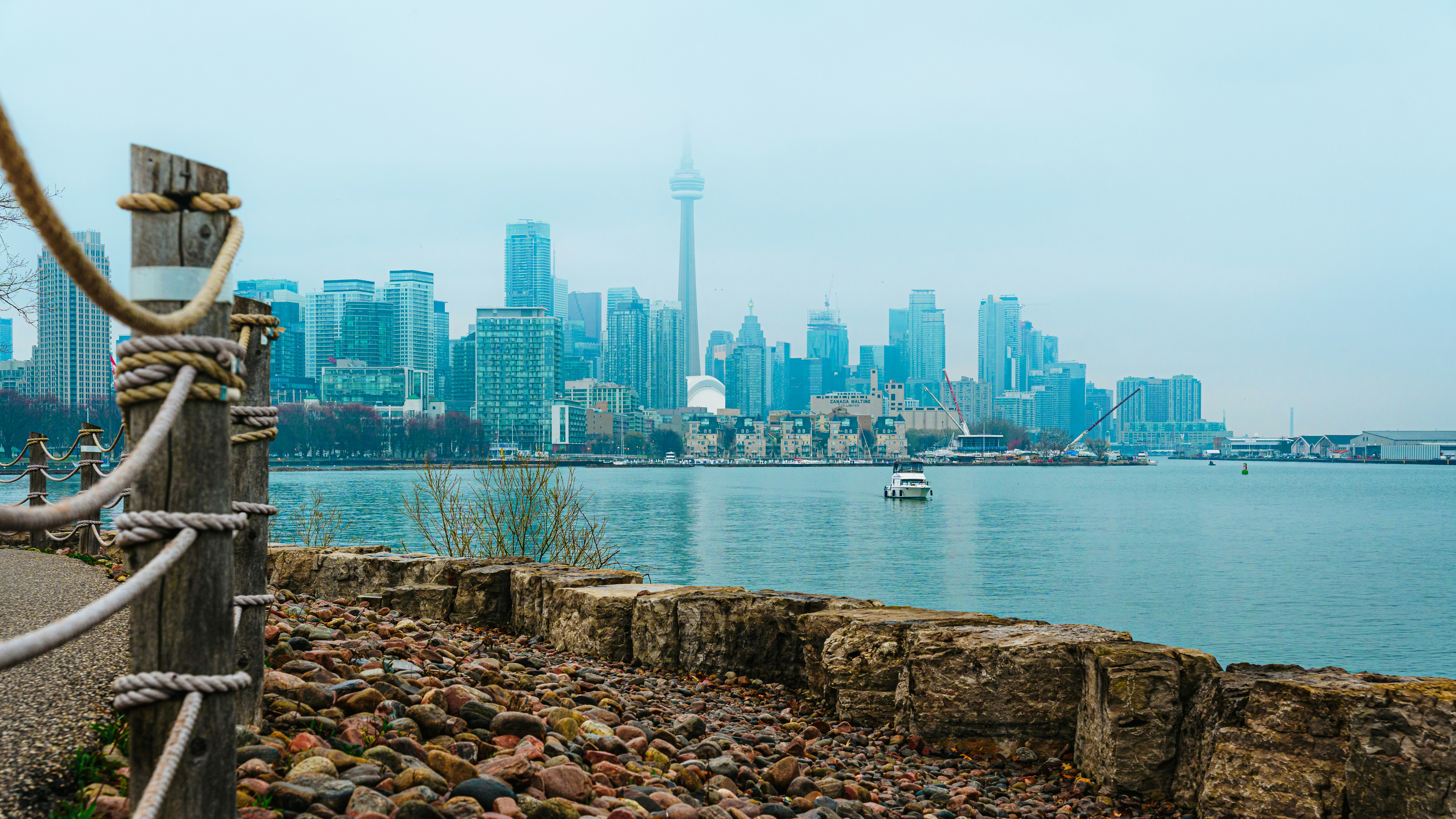 Toronto skyline on one foggy morning. | A city skyline is seen across the water.