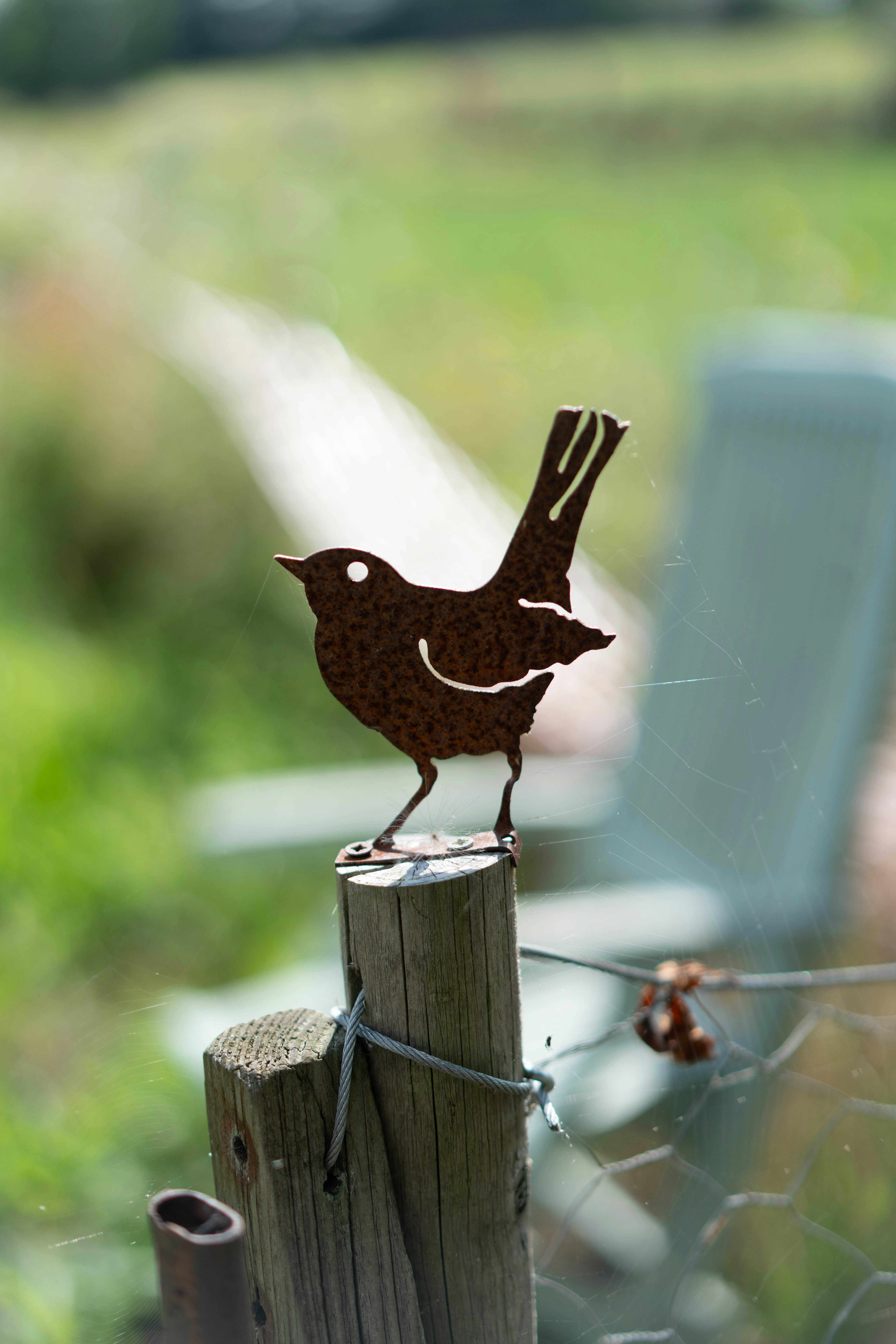 Whimsical Metal Bird Perched on a Rustic Post