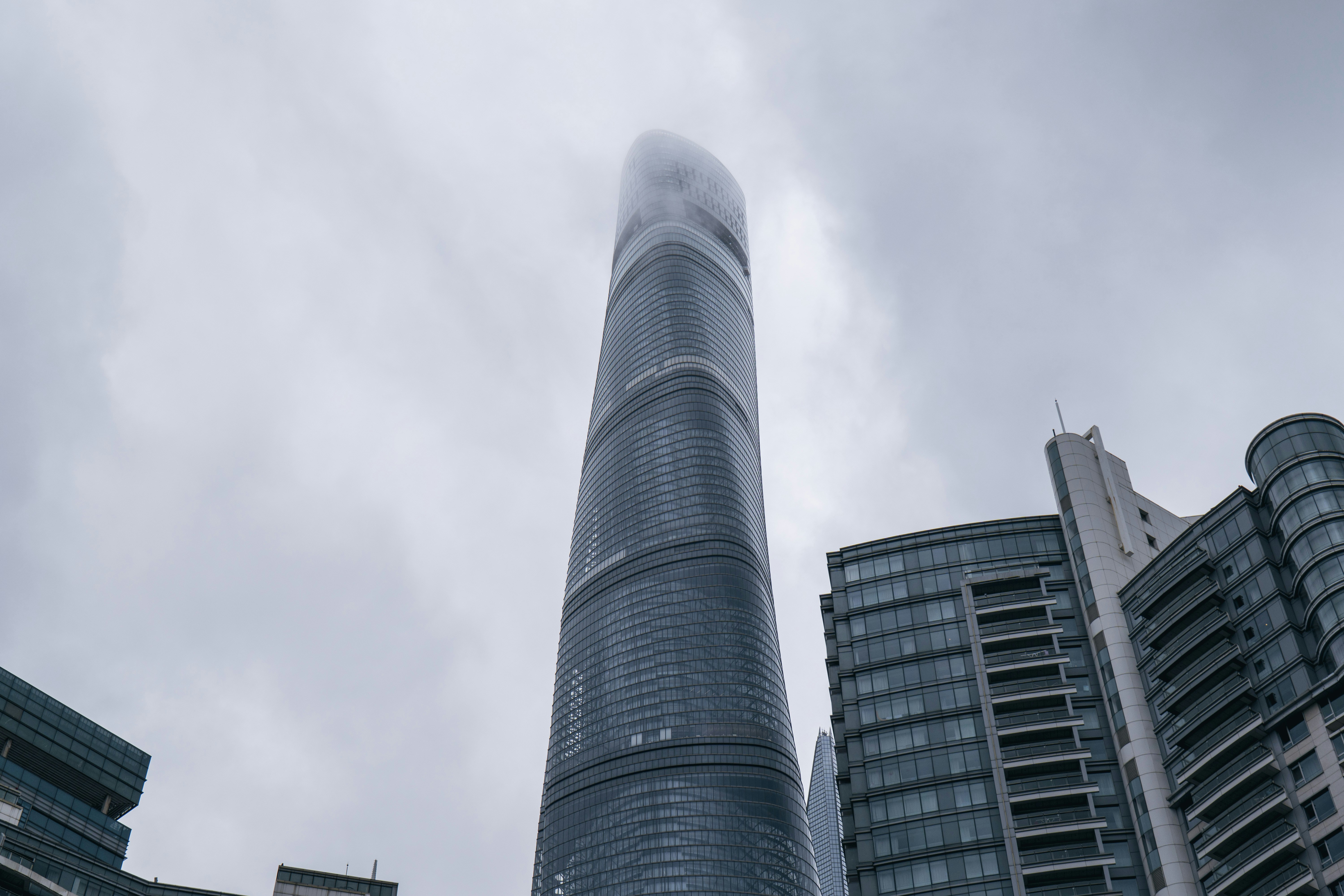 A tall skyscraper reaches into overcast clouds.