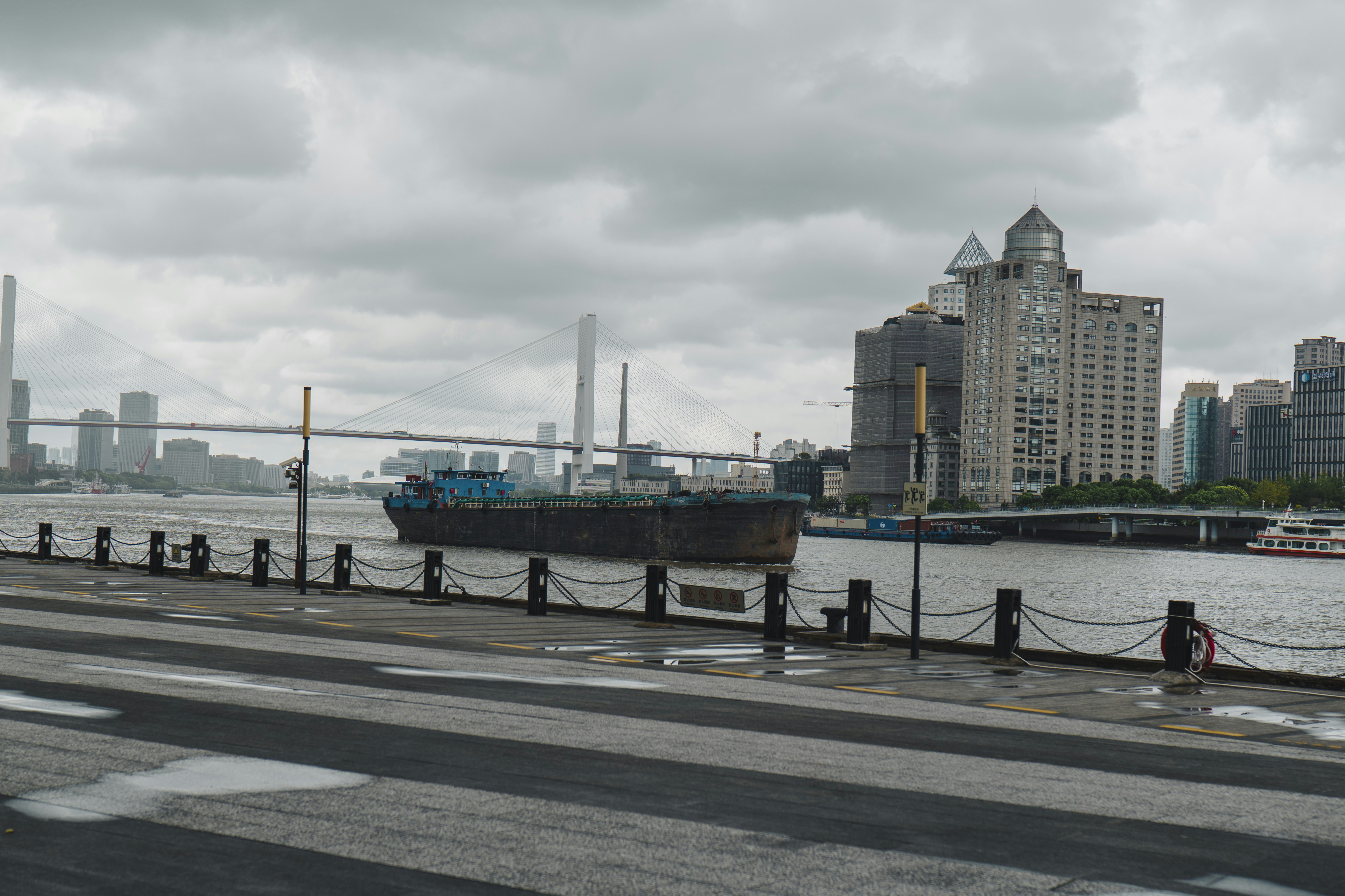 A ship sails on a river in a city.