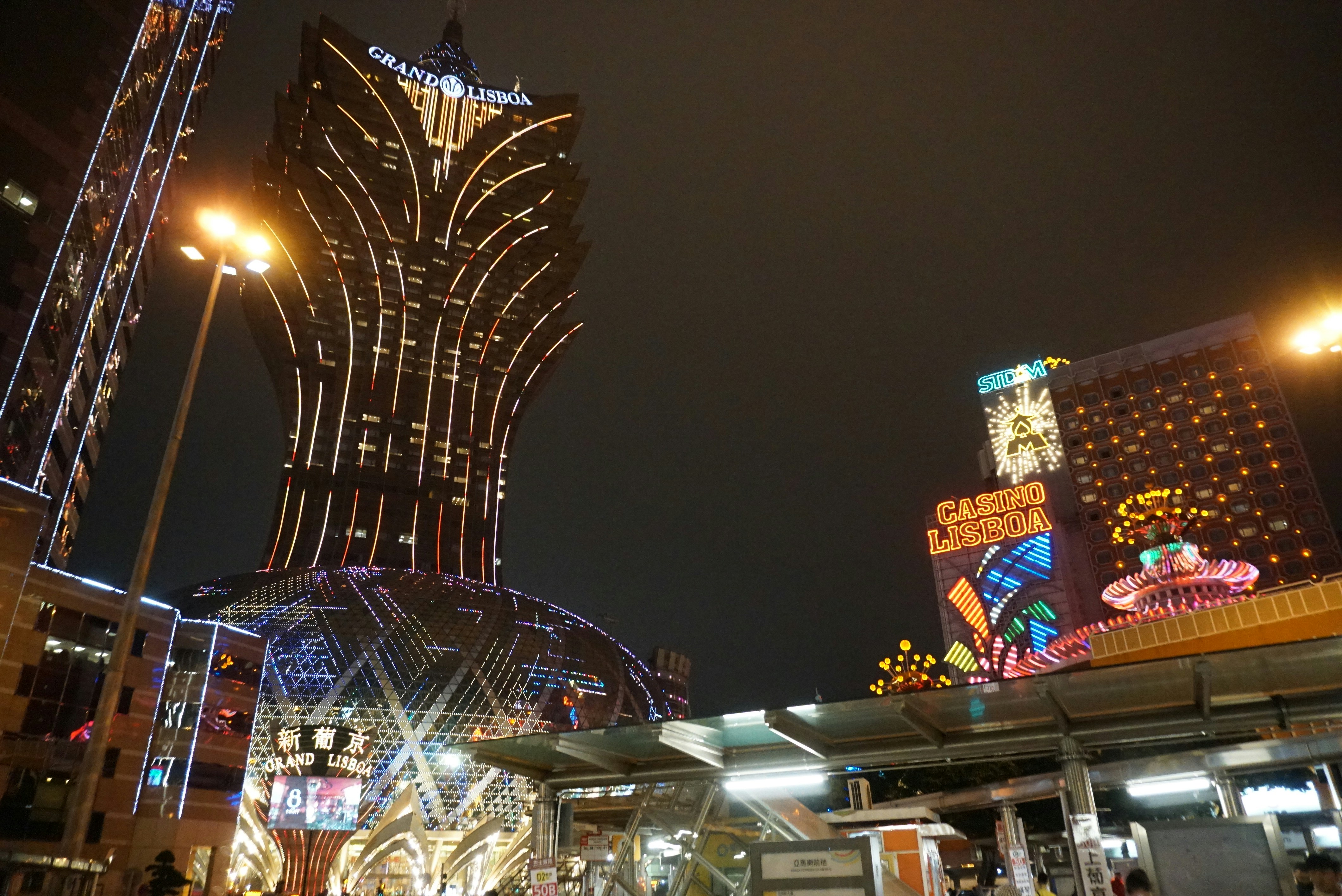 Illuminated skyscrapers and vibrant signage create a dazzling urban landscape at night, showcasing the lively atmosphere of a bustling casino district.