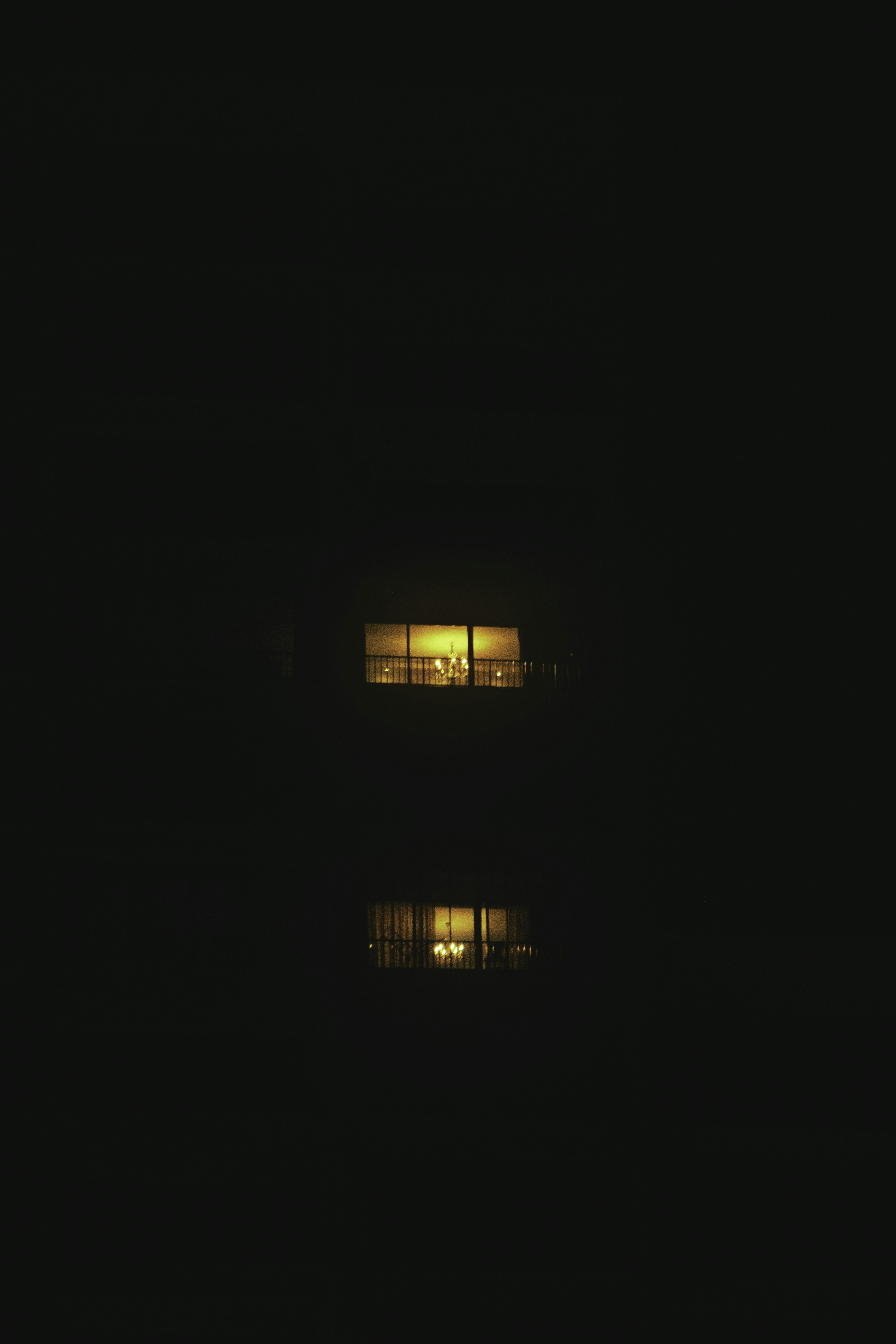 Window lights glow against a black backdrop.