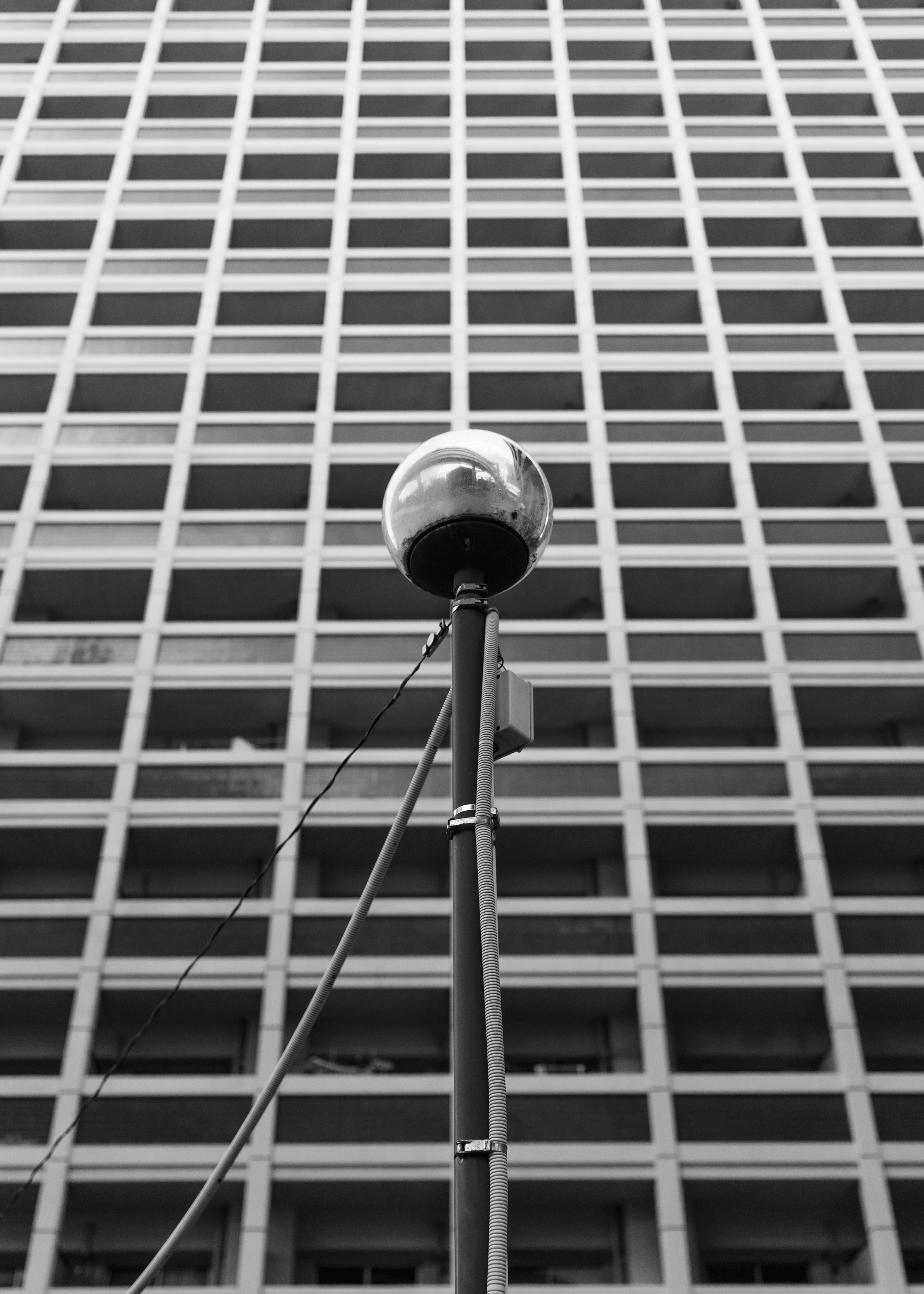 A lamp post stands before a high-rise building.
