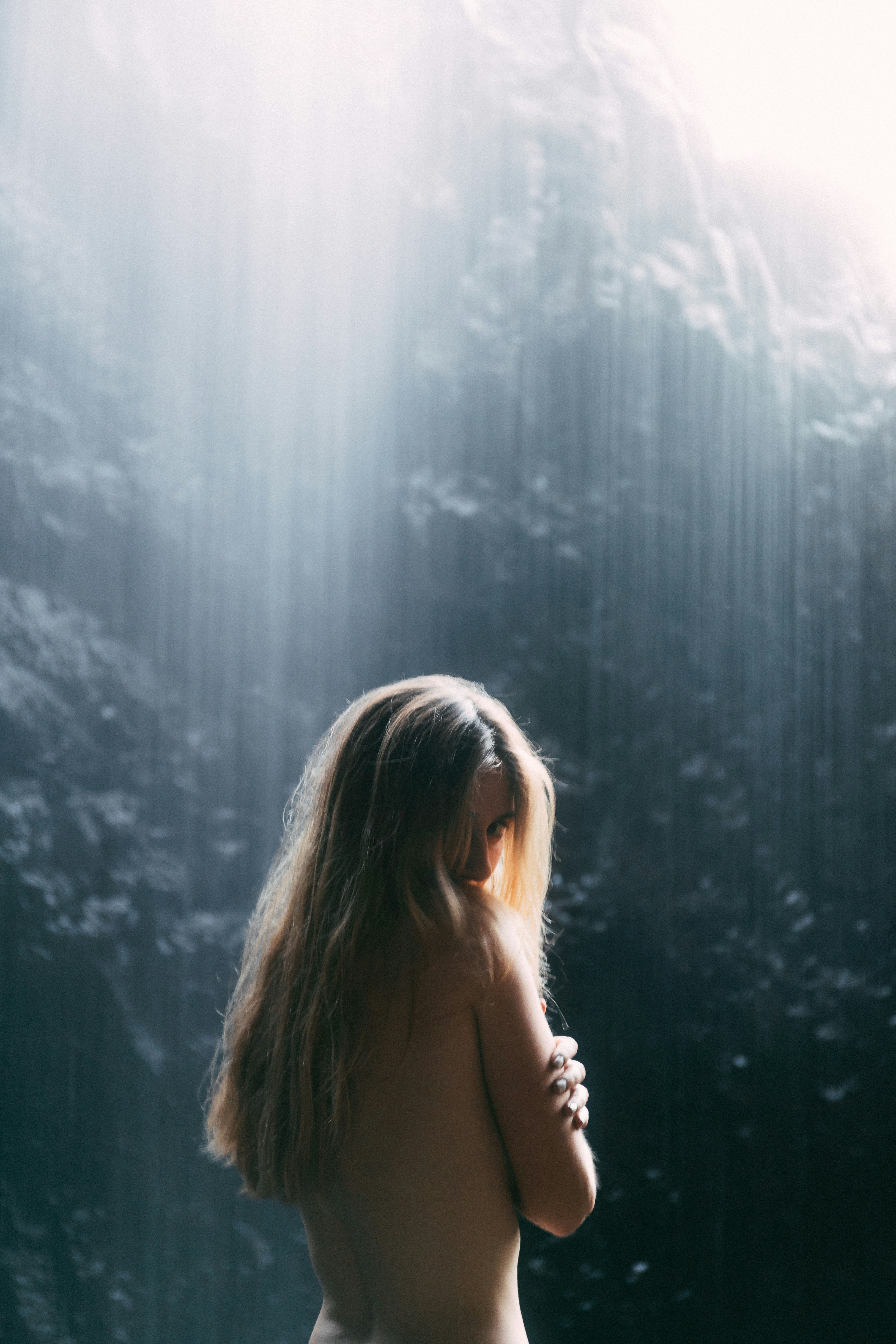 Povedz, komu dlžíš Ďakujem. | A woman stands in a waterfall.