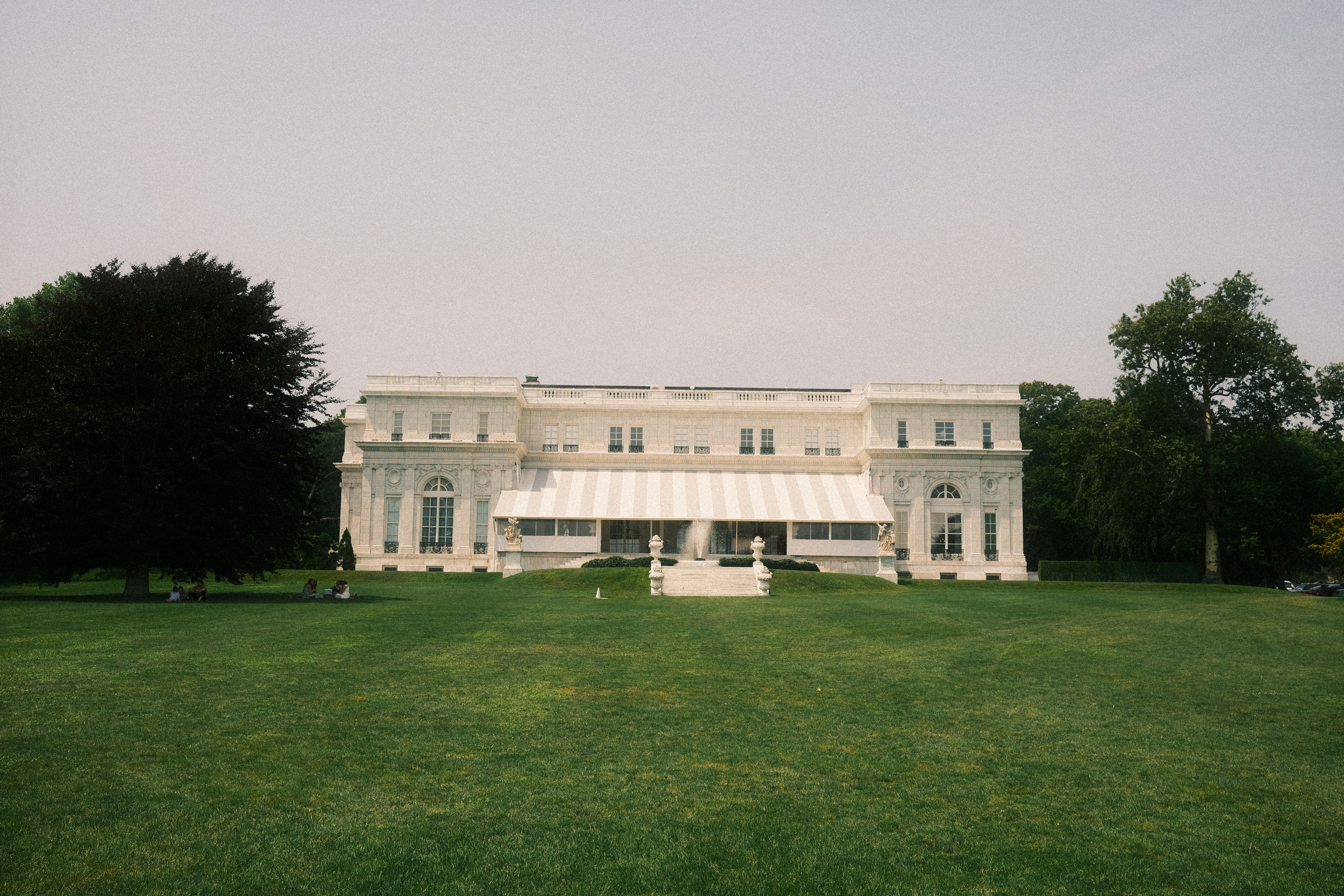 A large white house sits on green grass.