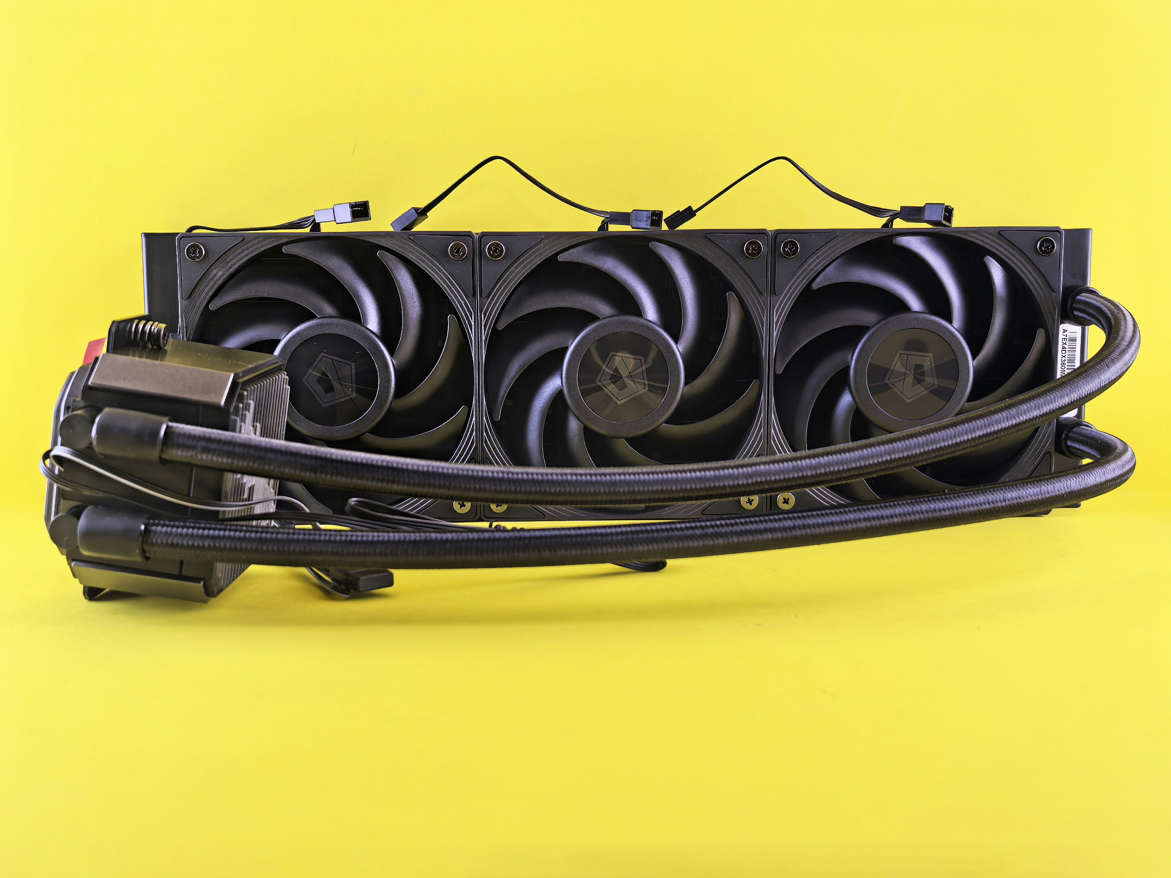 A sleek liquid cooling system featuring three fans and a pump, set against a bright yellow backdrop.