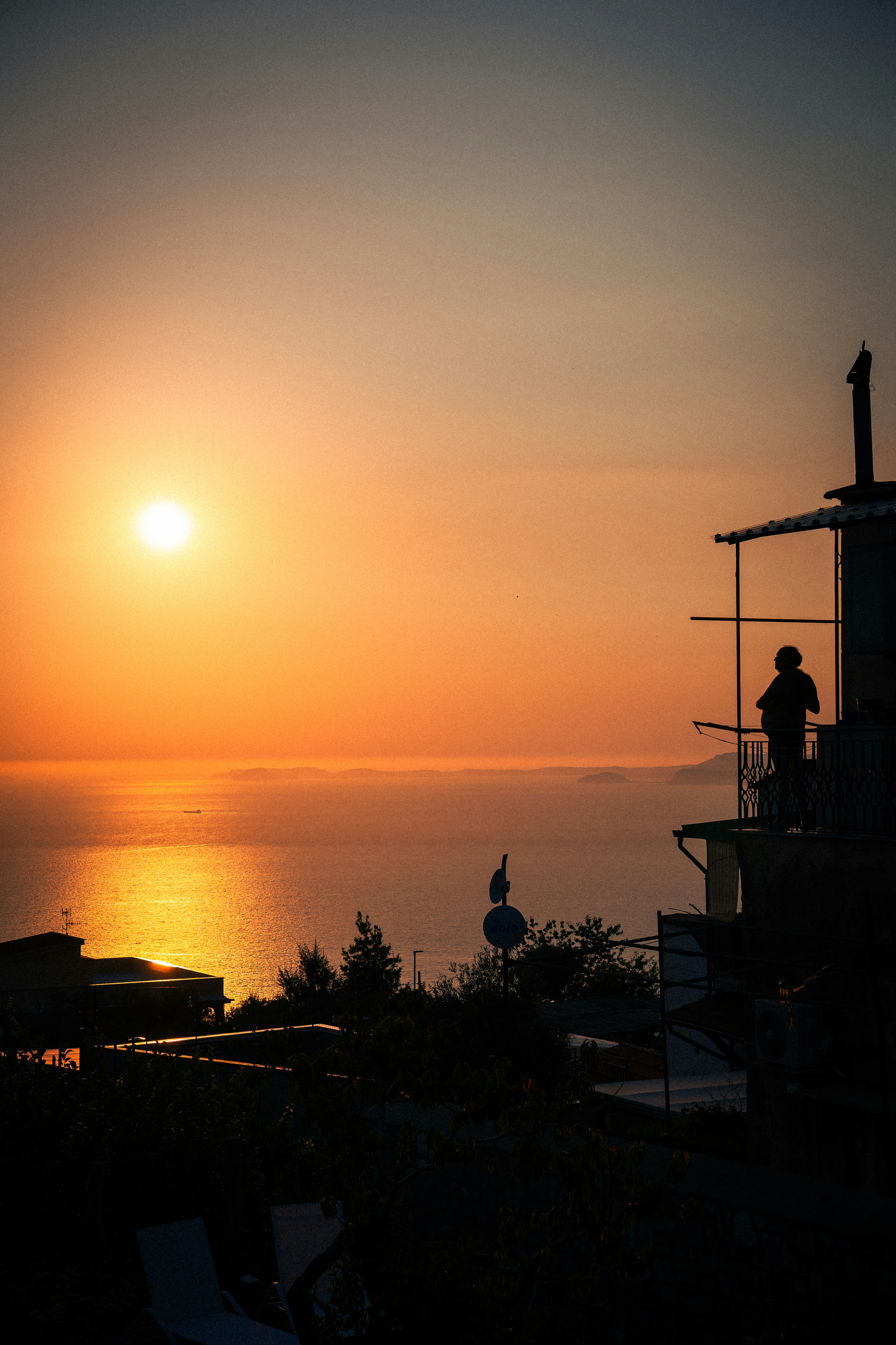 Old man at sunset | A person watches the sunset over the ocean.