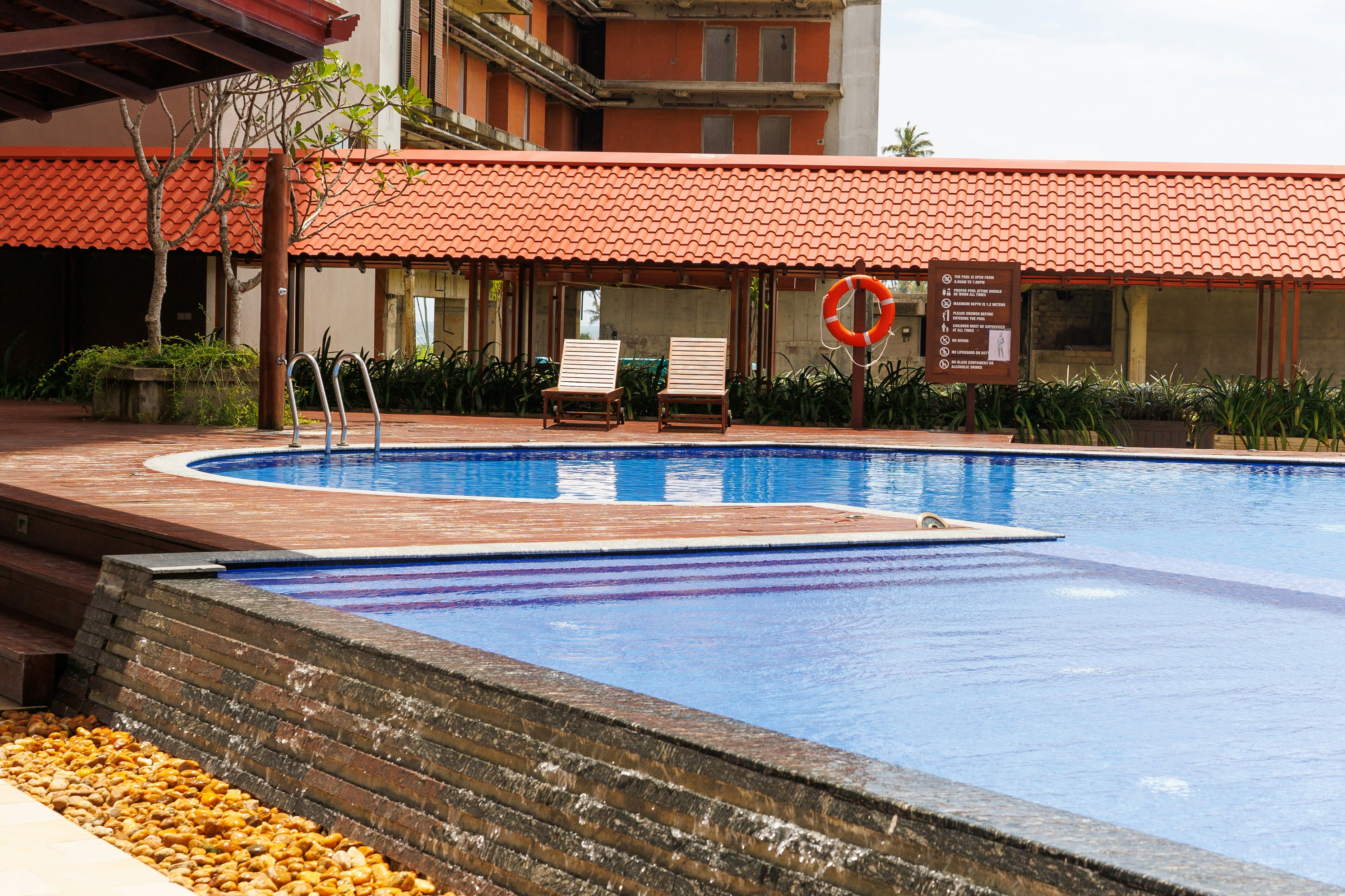 A swimming pool surrounded by relaxation amenities.